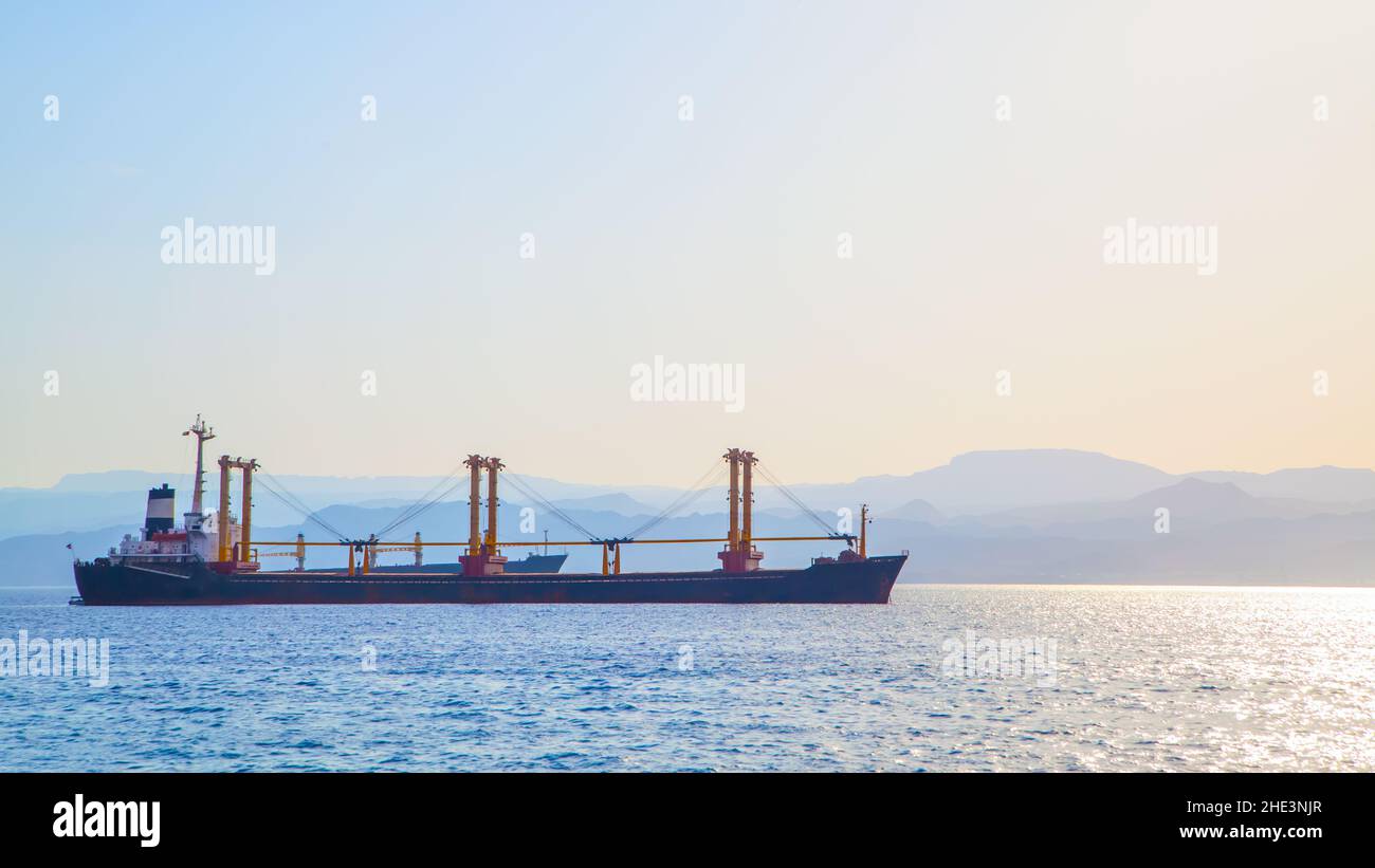 Colorful seascape with cargo ship Stock Photo - Alamy