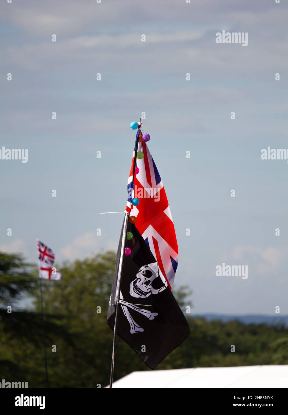 Union flag over a Jolly Roger pirate flag with flag of St George in the ...
