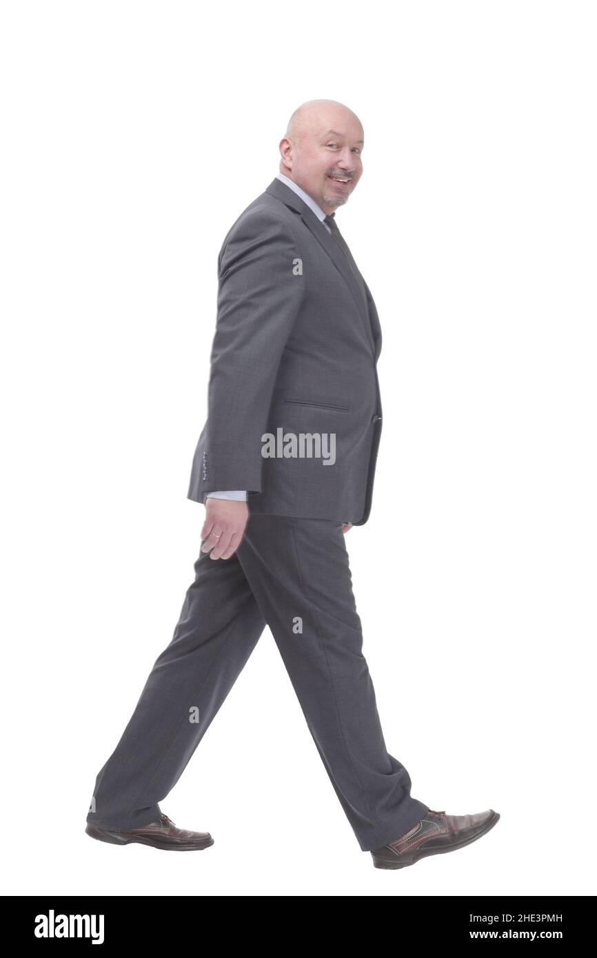 Mature business man striding forward .isolated on a white background ...