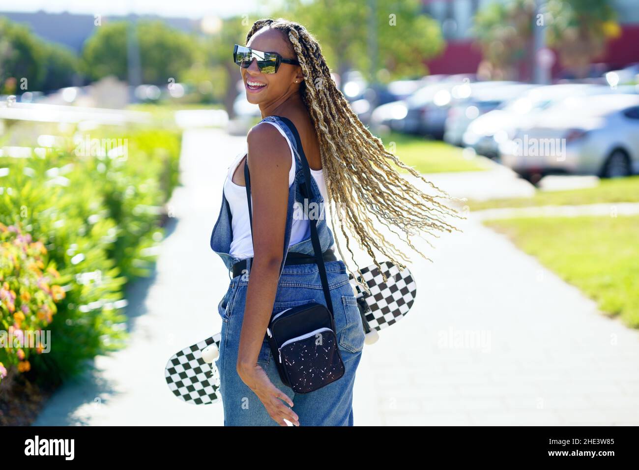 Black female moving her coloured braids in the wind. Typical African ...