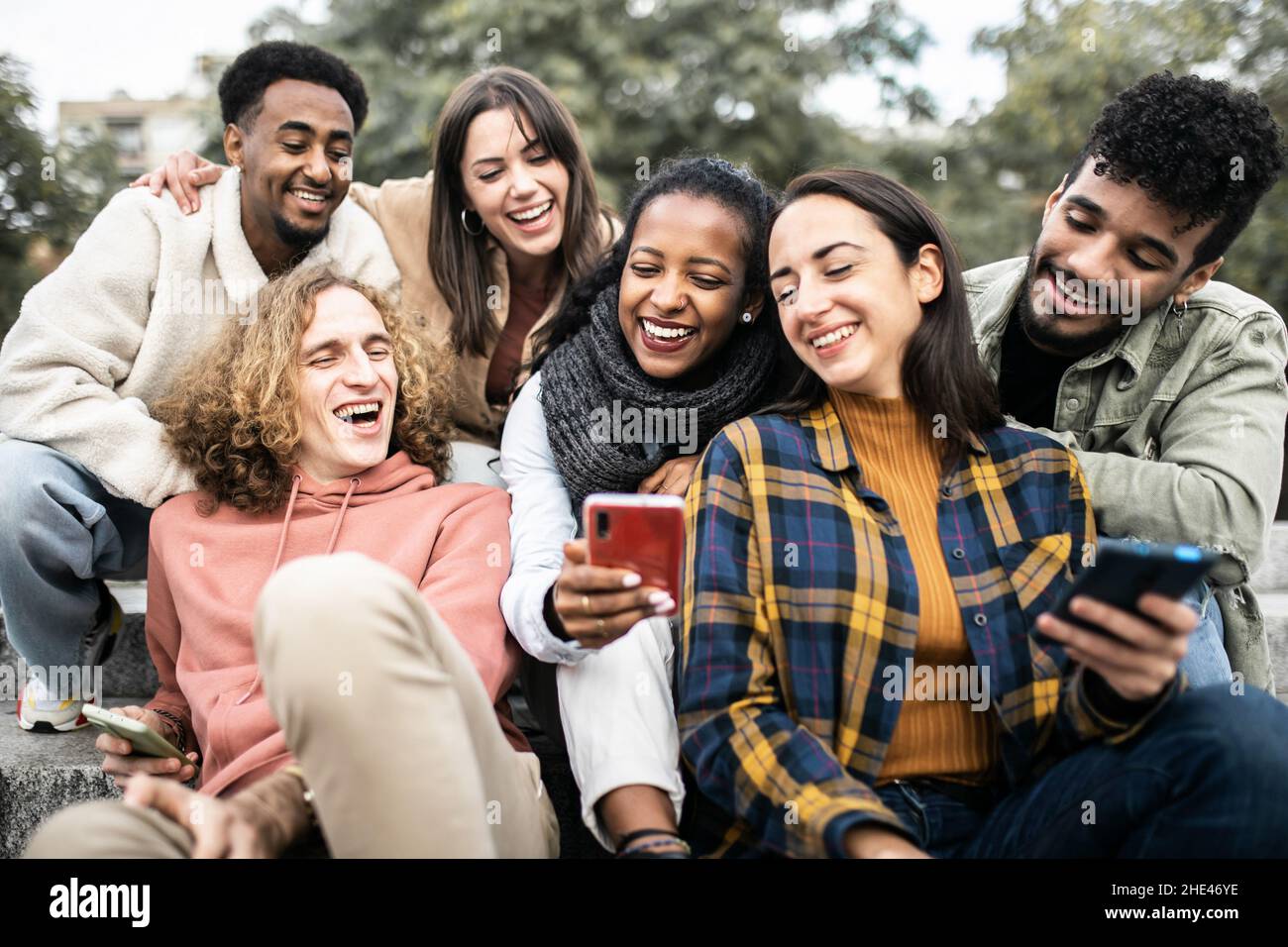 Happy group of young people having fun using smartphone outdoors Stock ...