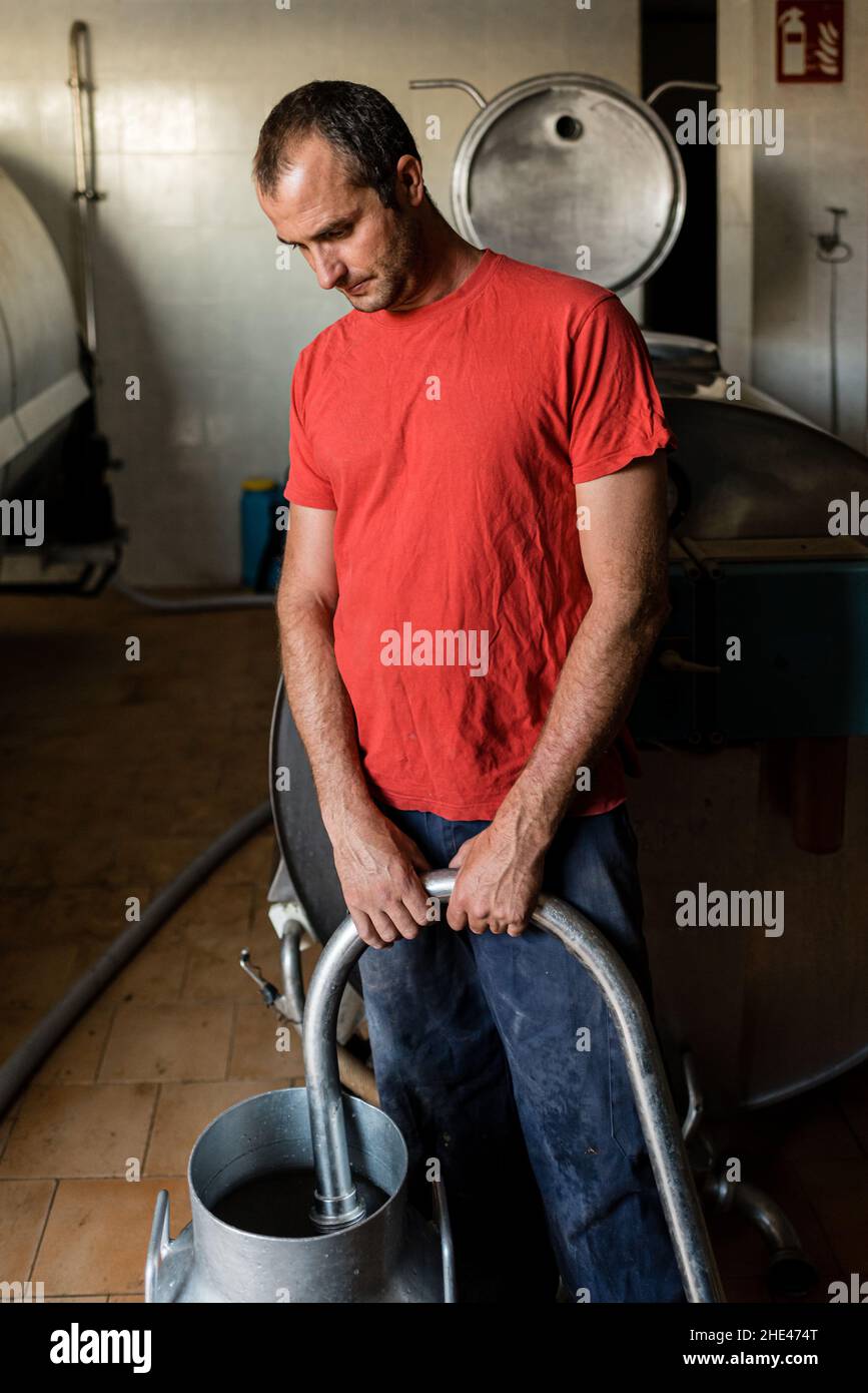 Farmer filling a container with fresh milk from the dairy farm Stock ...