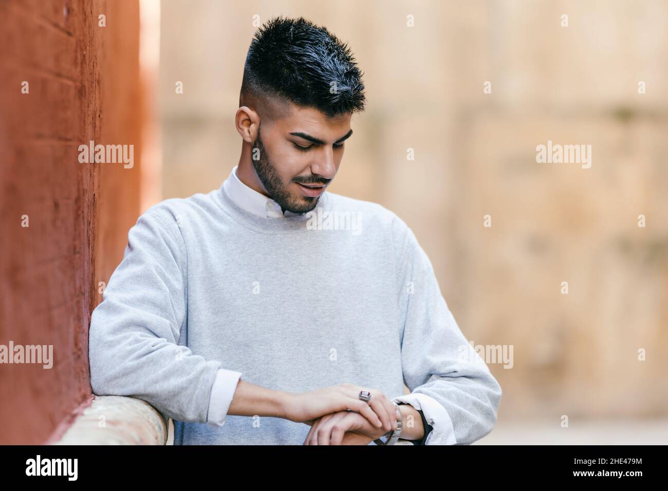 Man looking at his wristwatch while standing in the street Stock Photo ...