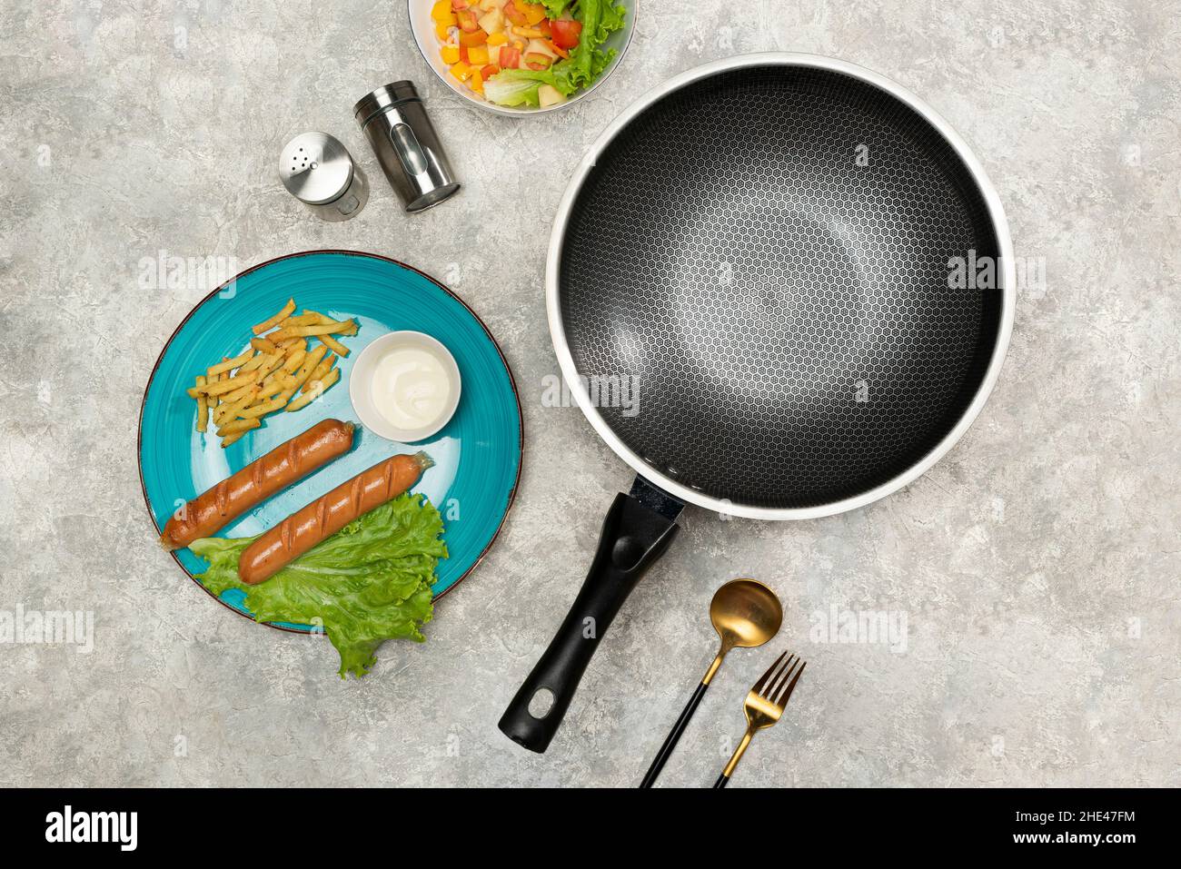 Flat lay of a frying pan with cooking spices and already made lunch on ...