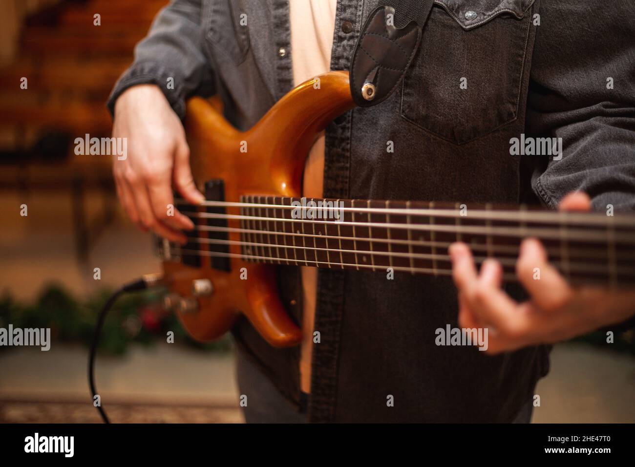 A young guy with a beard plays a bass guitar with five strings Stock ...