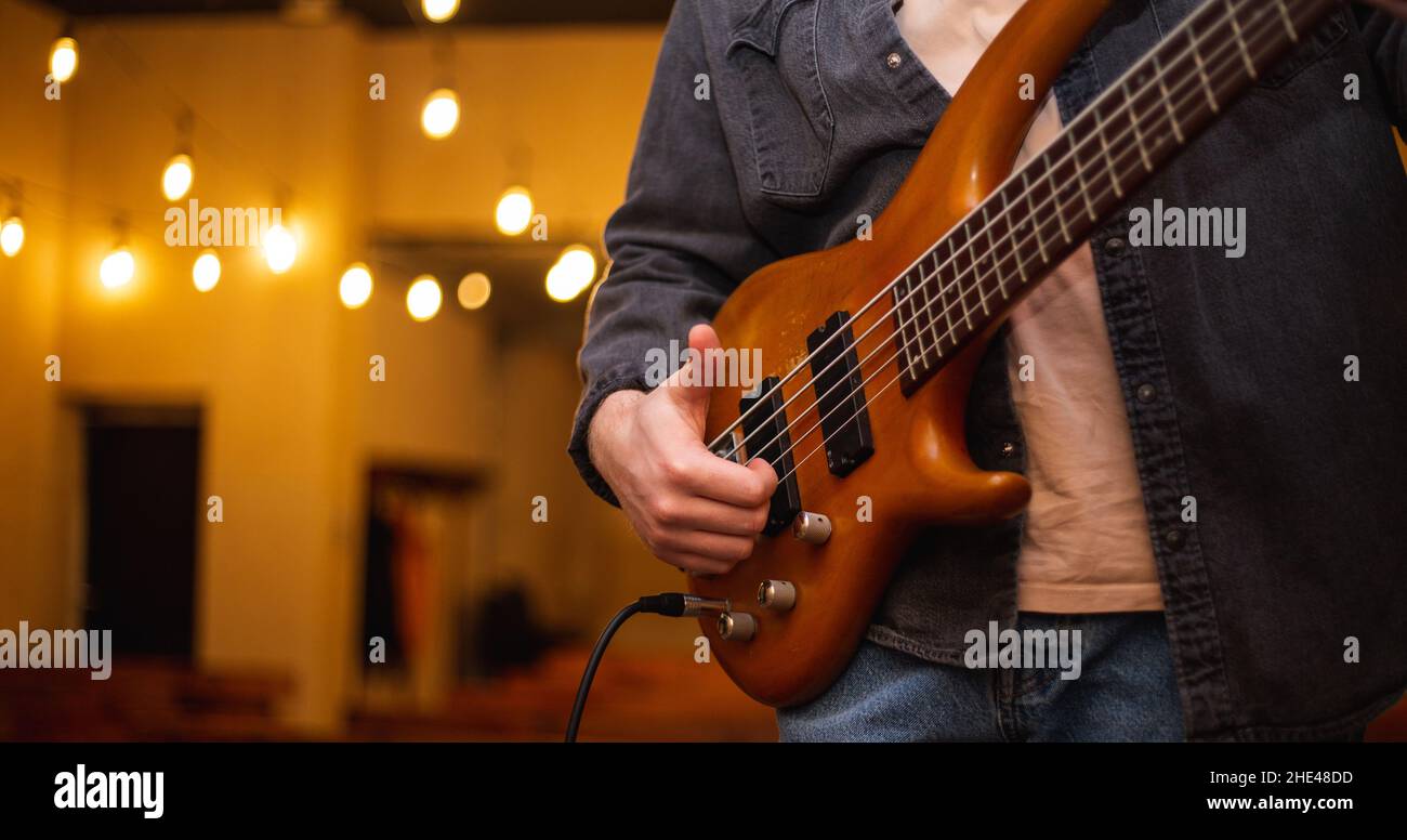 A young guy with a beard plays a bass guitar with five strings Stock ...