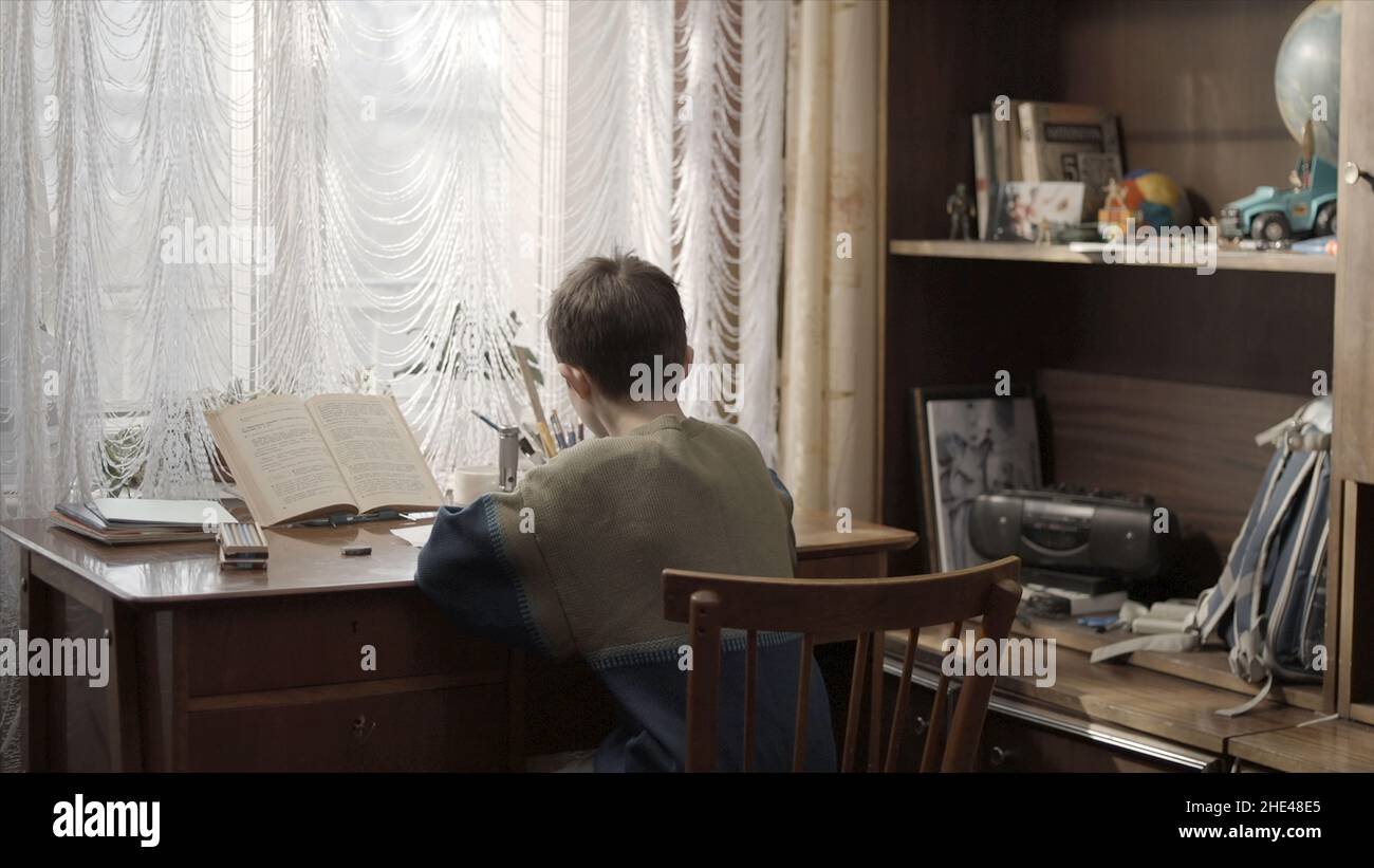 Rear view on guy doing homework. Thoughtful teen boy doing school ...