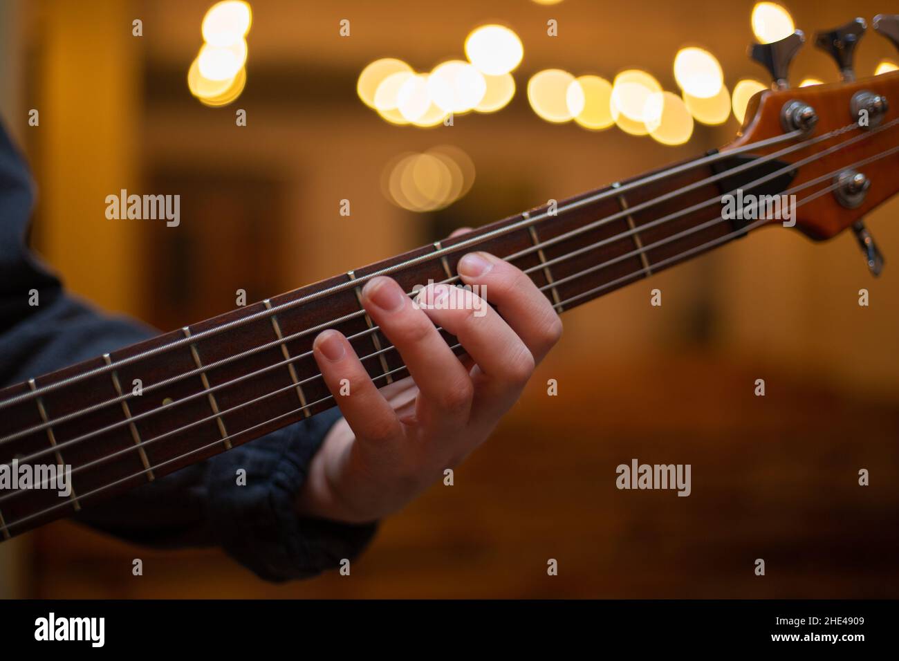 A young guy with a beard plays a bass guitar with five strings Stock ...