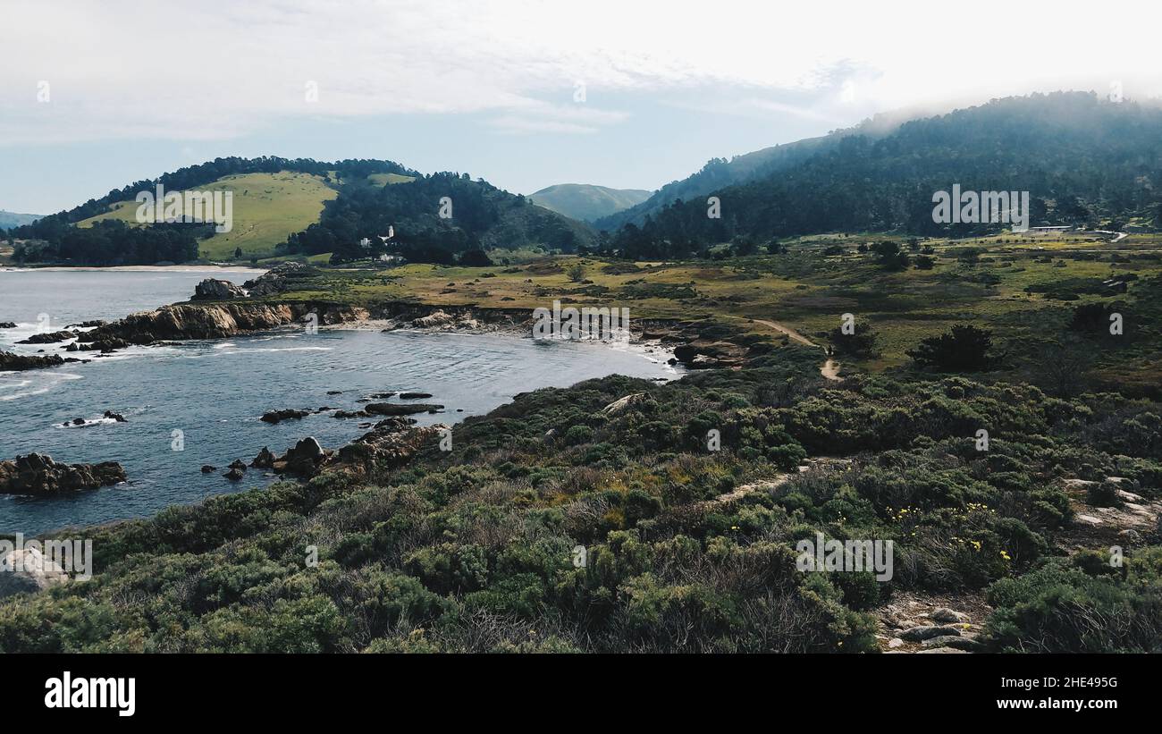 Cloudy sky over the sea and the forested coast in spring Stock Photo ...