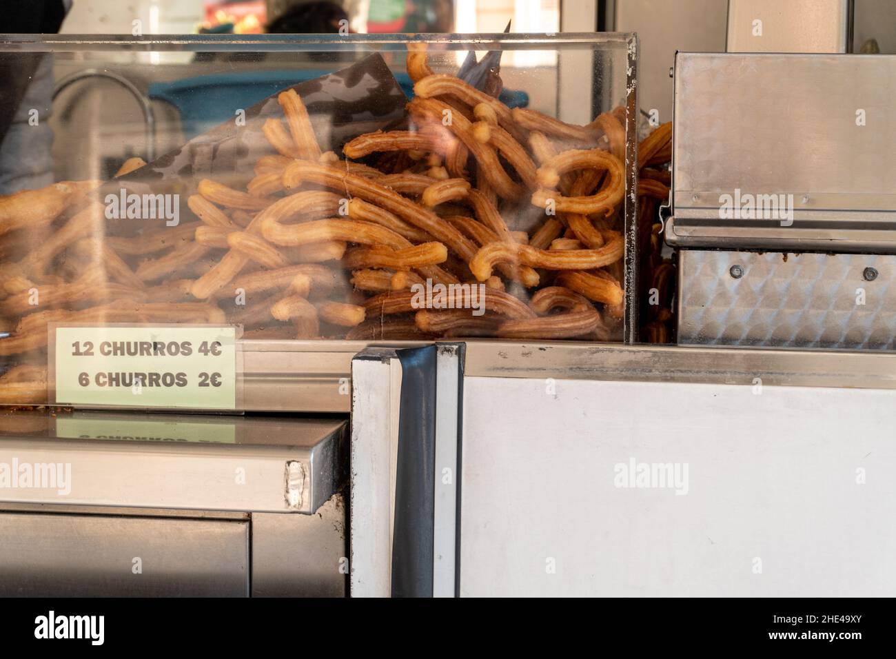 Beautiful shot of churros behind the display, with the price poster ...