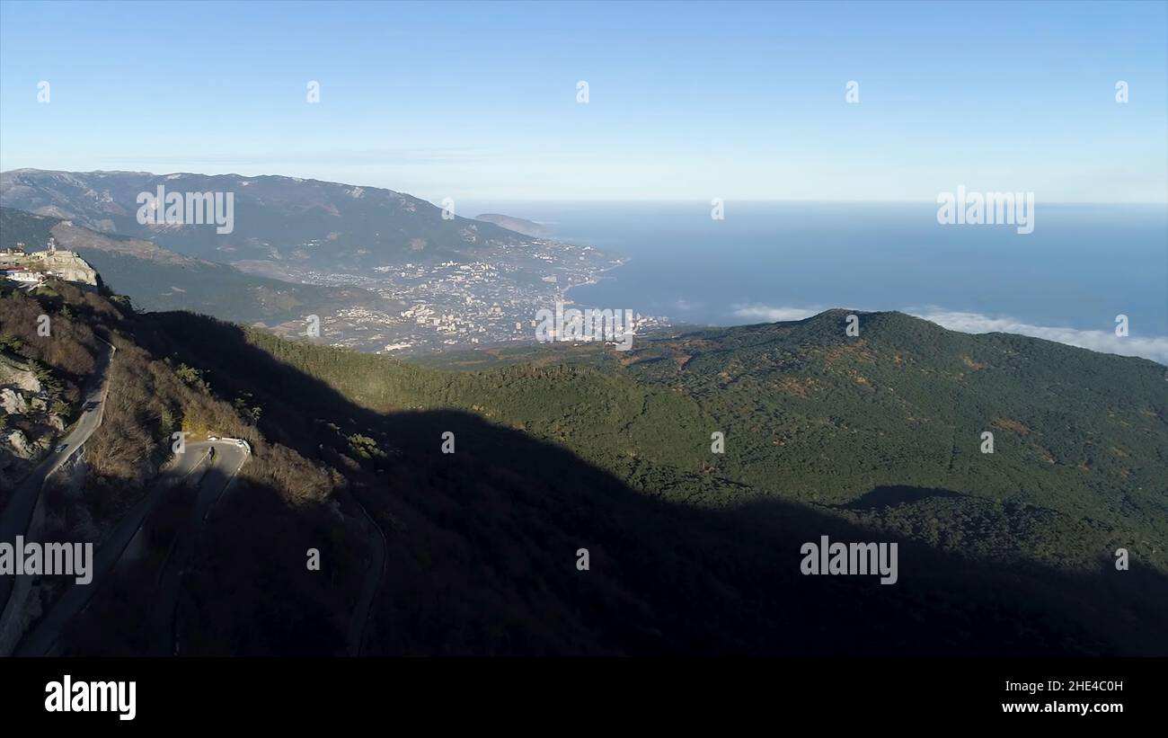 Aerial view from high mountain to a seaside town and steep slope ...