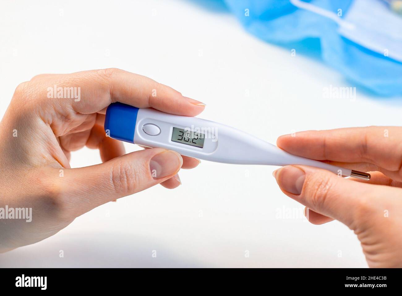 Woman hands holding a medicine digital thermometer with high body ...