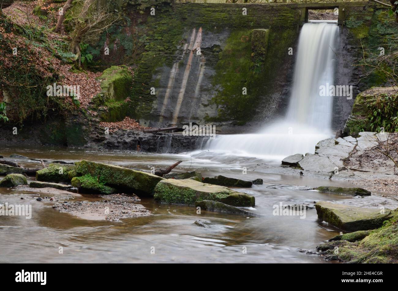 Scenic view of a waterfall flowing down the rocks covered with moss in ...