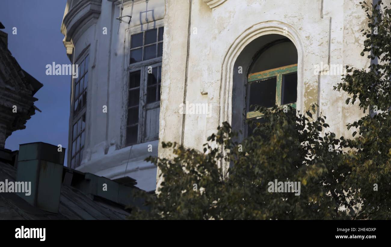 Side view of an ancient church wall. Wooden windows and white walls of ...