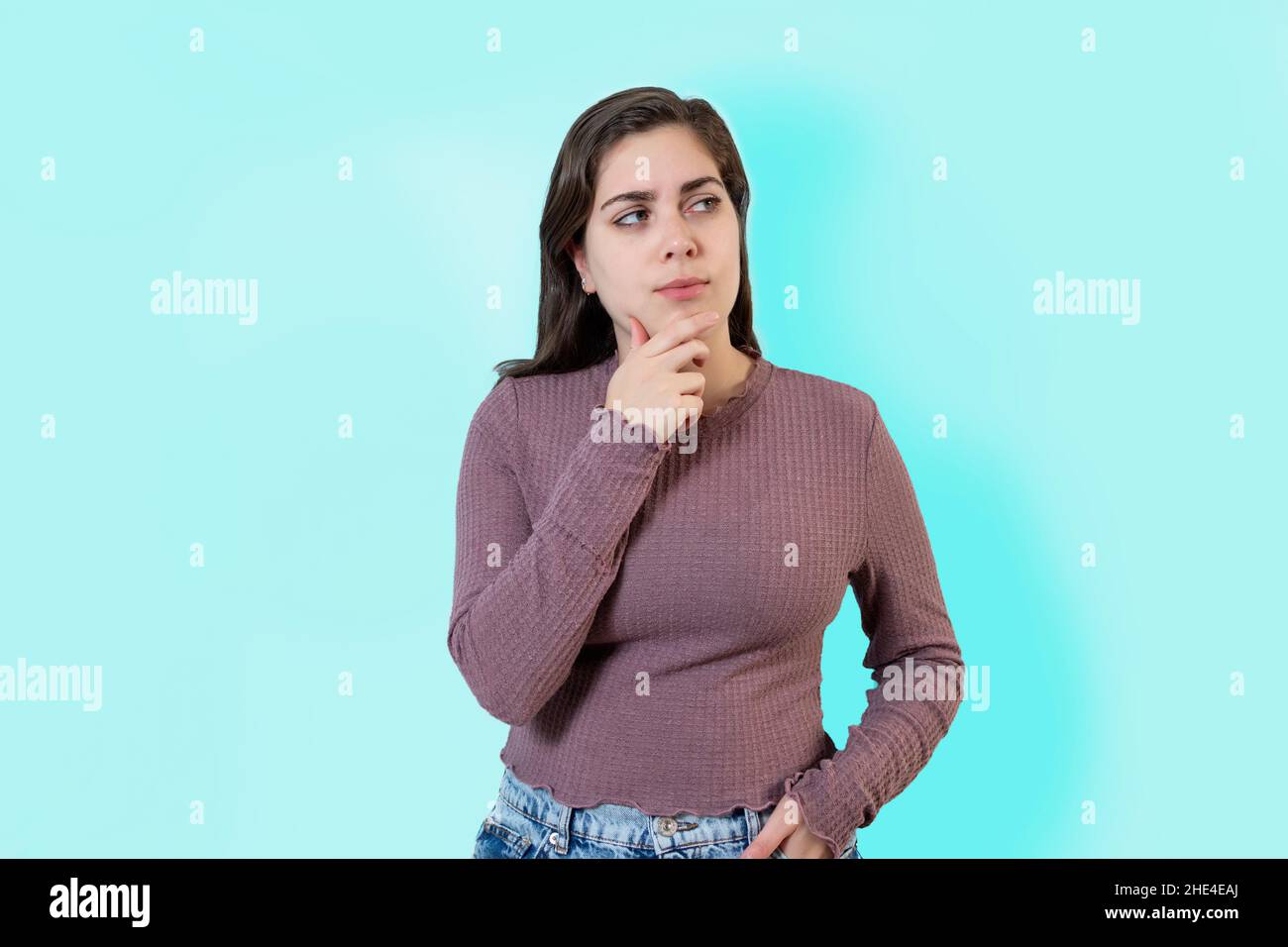 Woman with a concentrated look, wondering with a doubtful expression ...