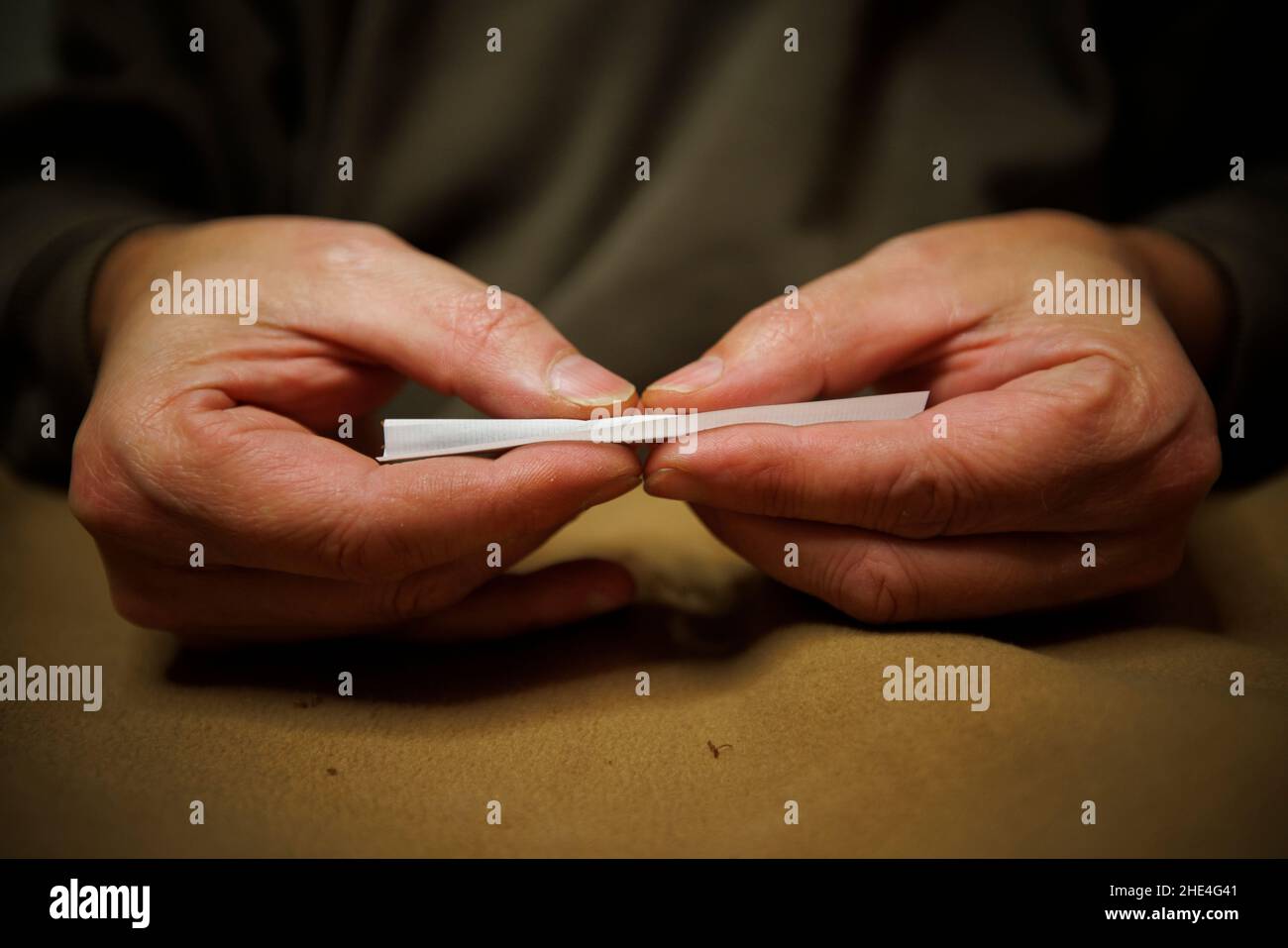A man rolls a cigarette paper and fills it with loose tobacco Stock ...