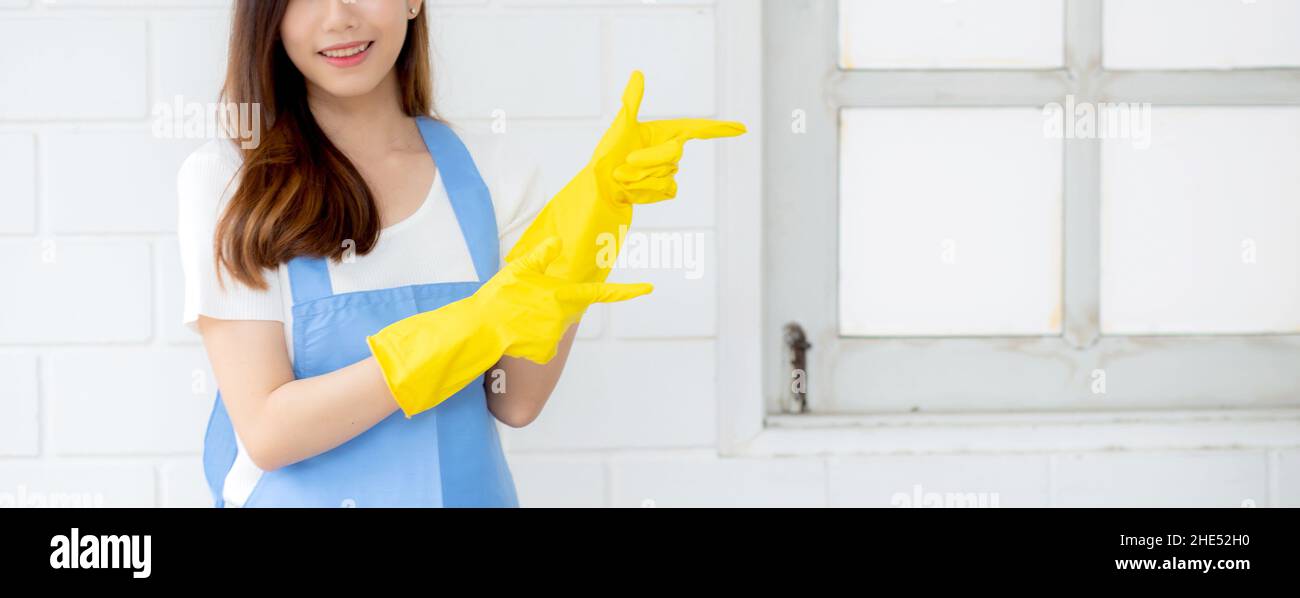 Portrait young asian woman is housekeeper in rubber gloves and apron ...