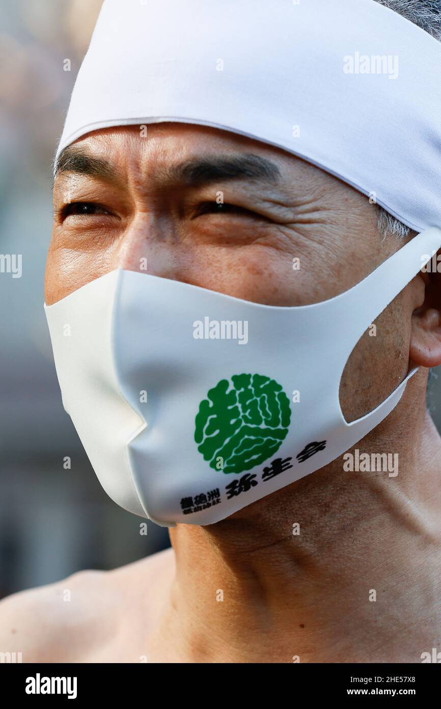 Tokyo, Japan. 9th Jan, 2022. A participant, wearing a face mask, warms ...
