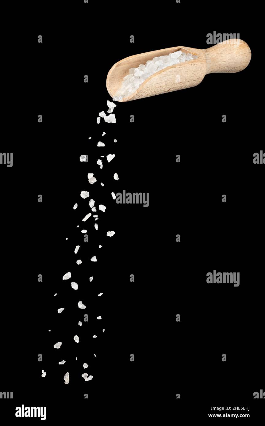 white sea salt falling from wooden spoon isolated Stock Photo - Alamy