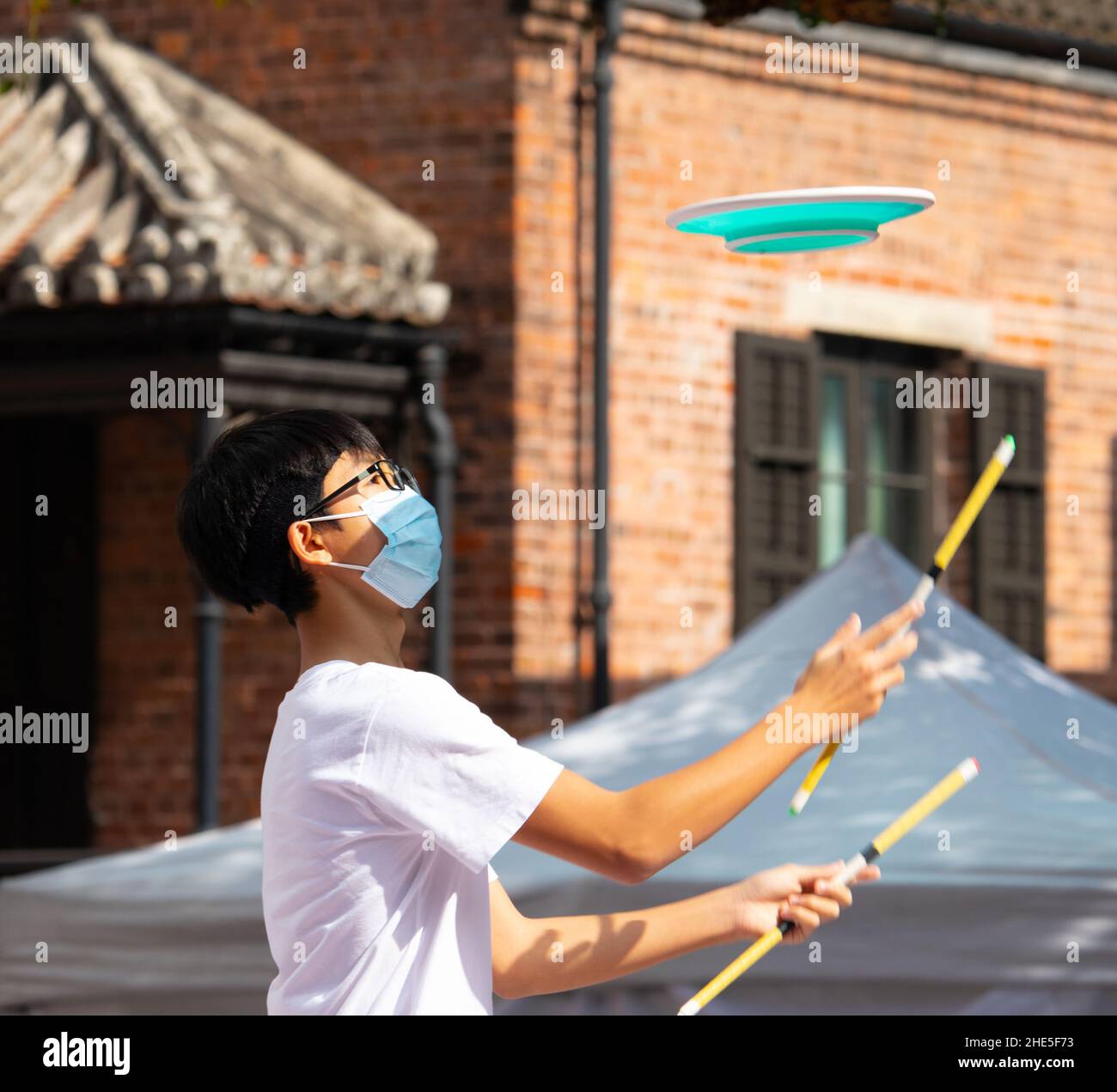 Teenage boys practice spinning and juggling plates for a public ...
