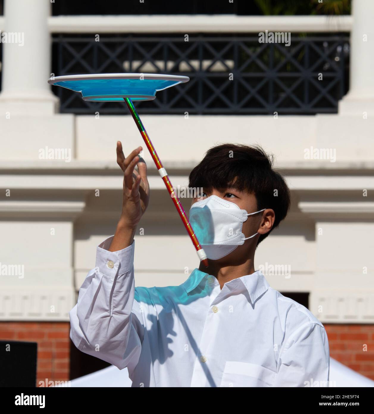 Teenage boys practice spinning and juggling plates for a public ...
