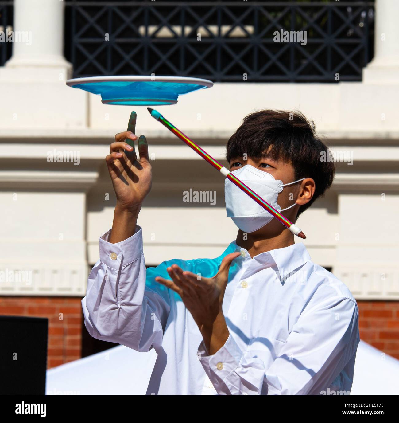 Teenage boys practice spinning and juggling plates for a public ...