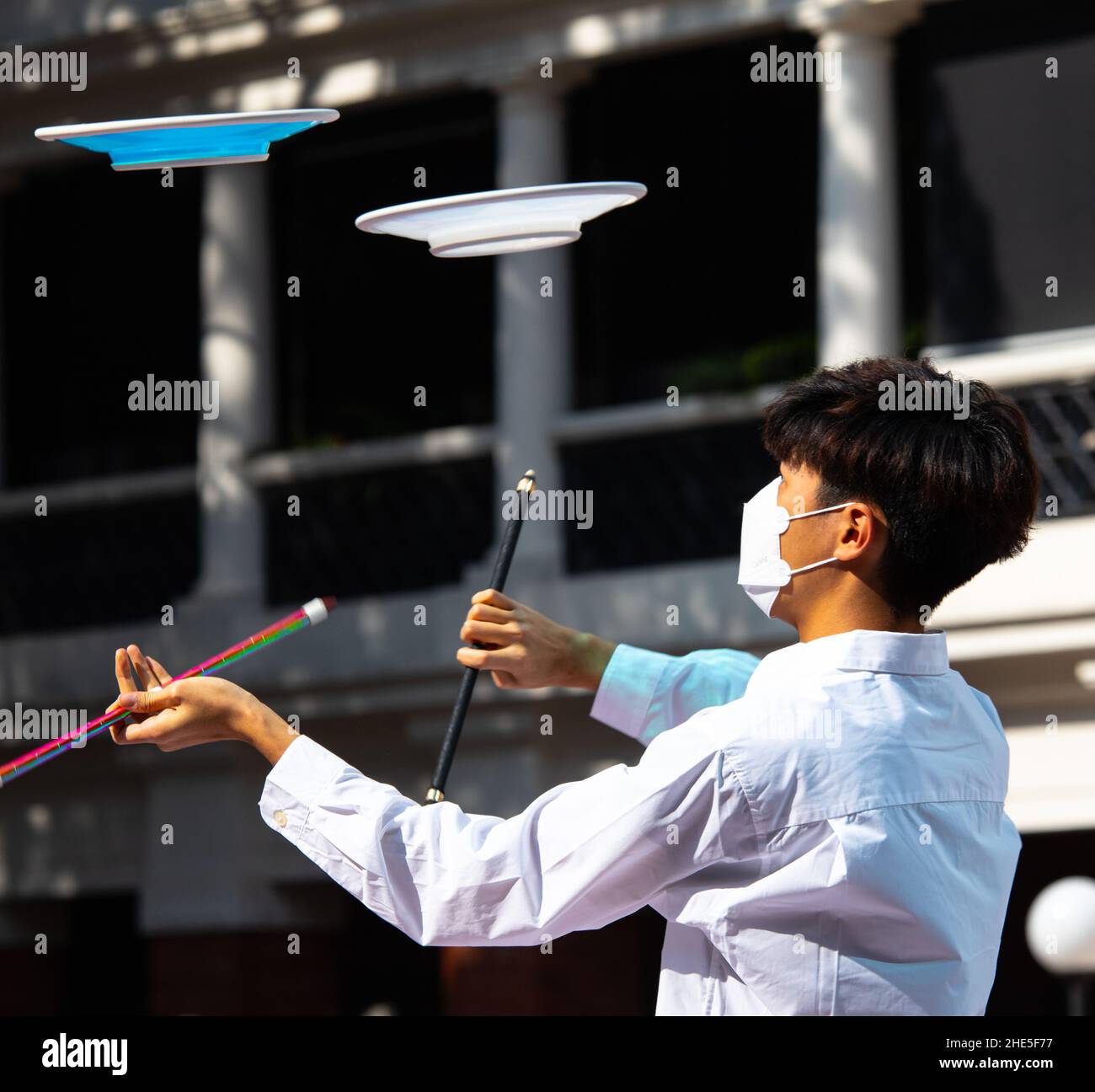 Teenage boys practice spinning and juggling plates for a public ...