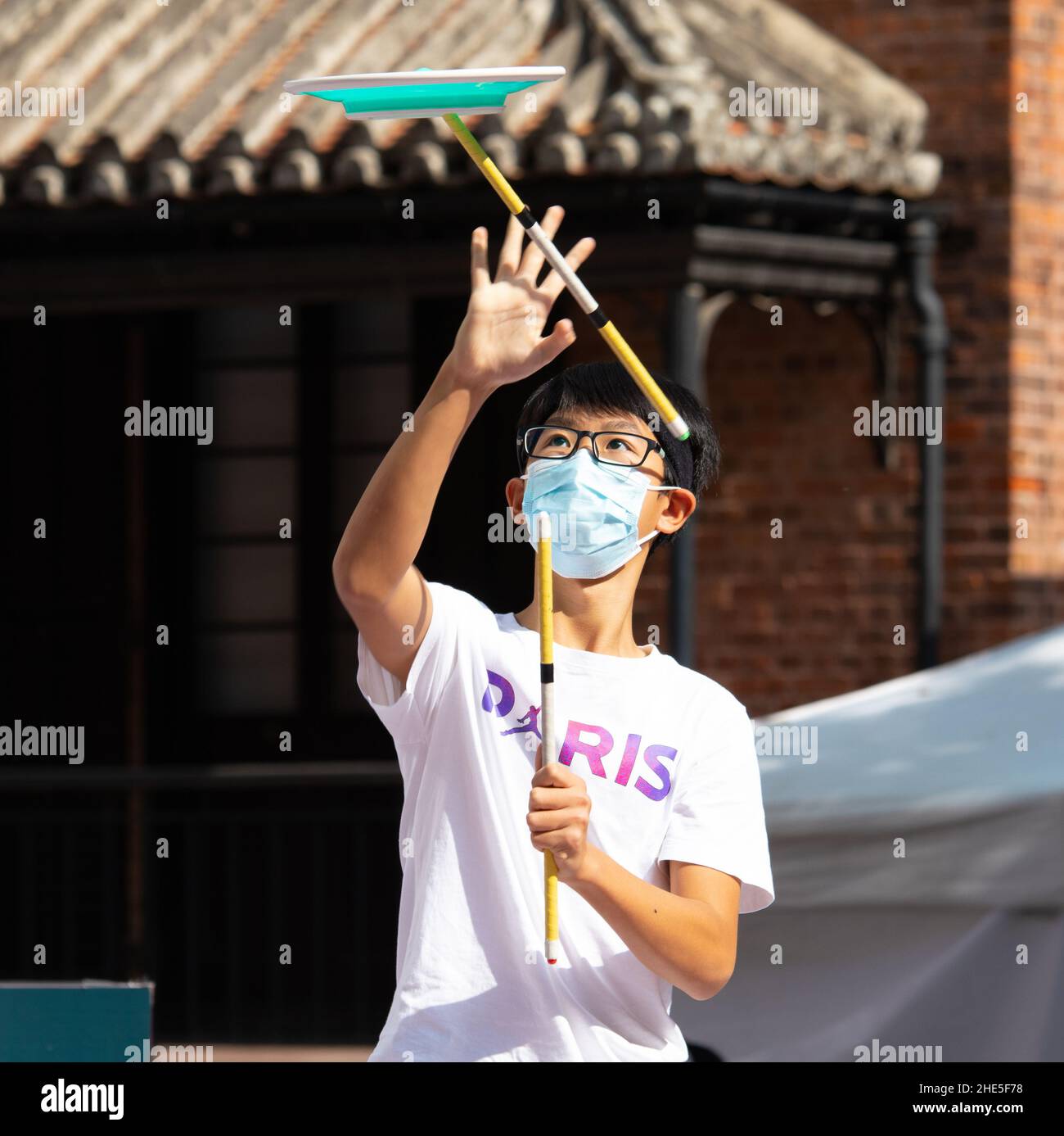 Teenage boys practice spinning and juggling plates for a public ...