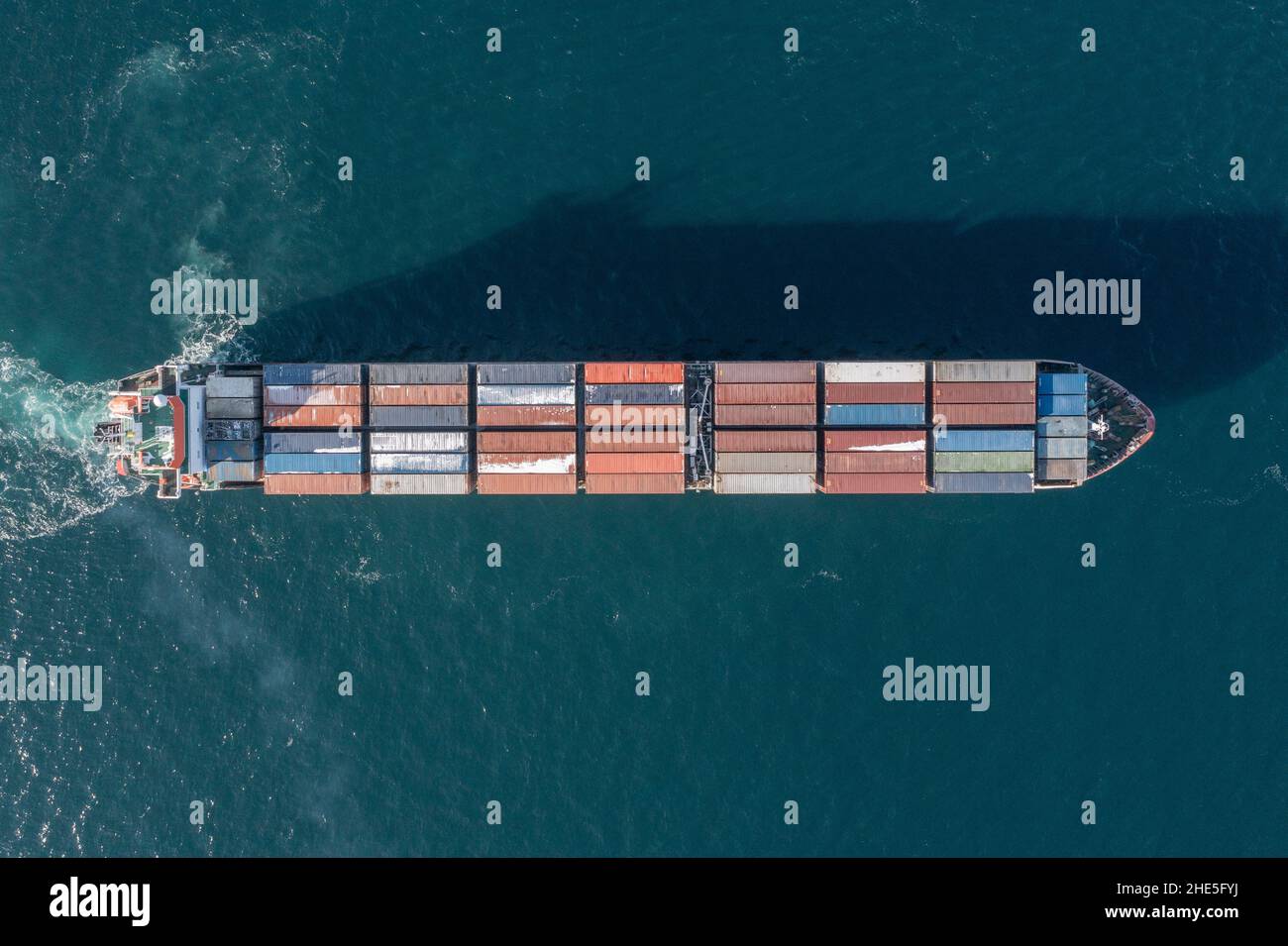 Sea container ship is moving at sea. Around the foam from the work of ...
