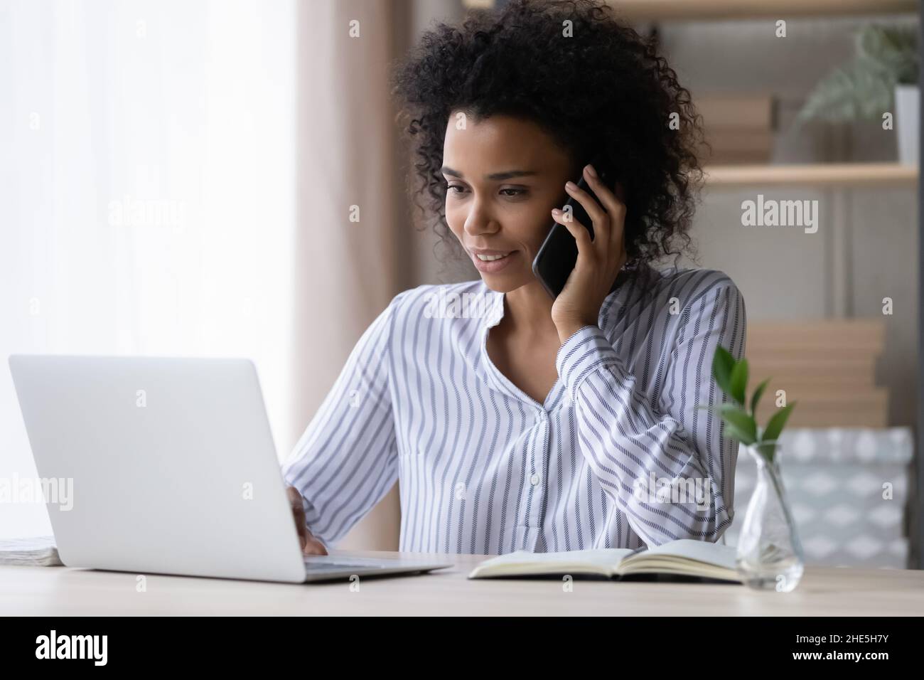 Focused beautiful millennial african ethnicity woman multitasking in ...