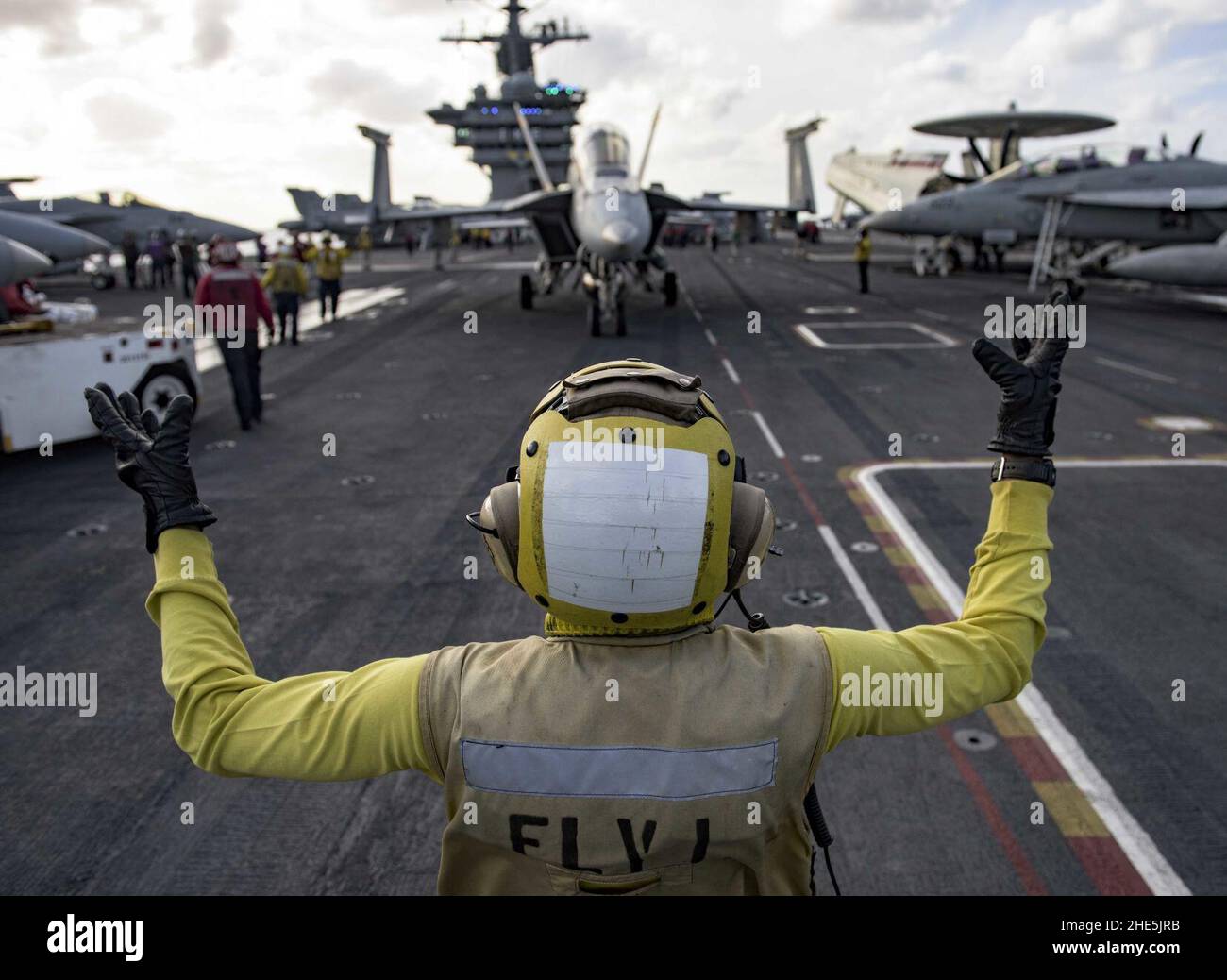 Sailor directs an F-A-18F Super Hornet on the flight deck of the USS ...