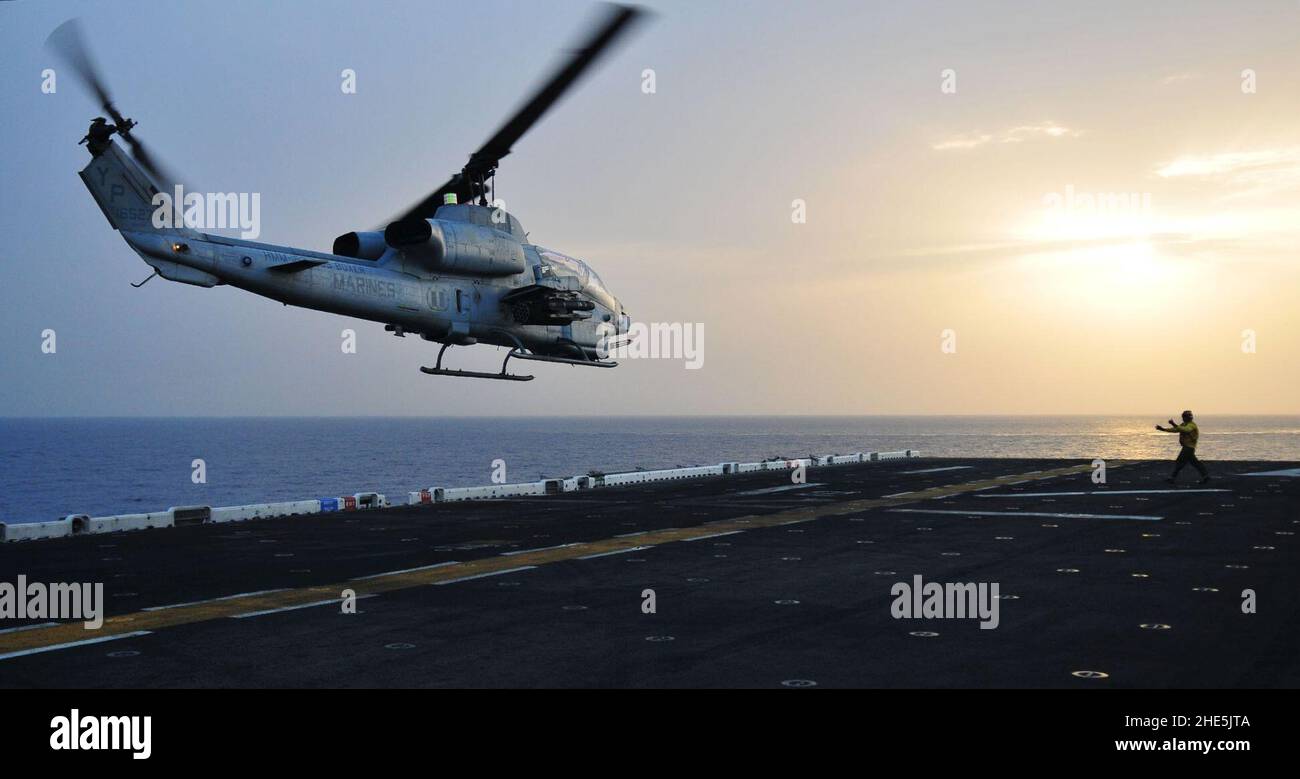 Sailor directs an AH-1 Cobra helicopter to take off from USS Boxer ...