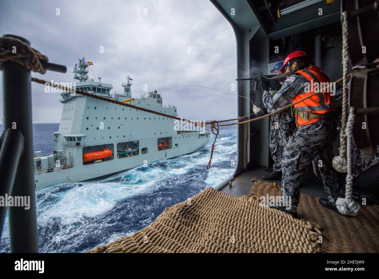 Sailor firing a shot line from HMAS Adelaide to MV Asterix during ...