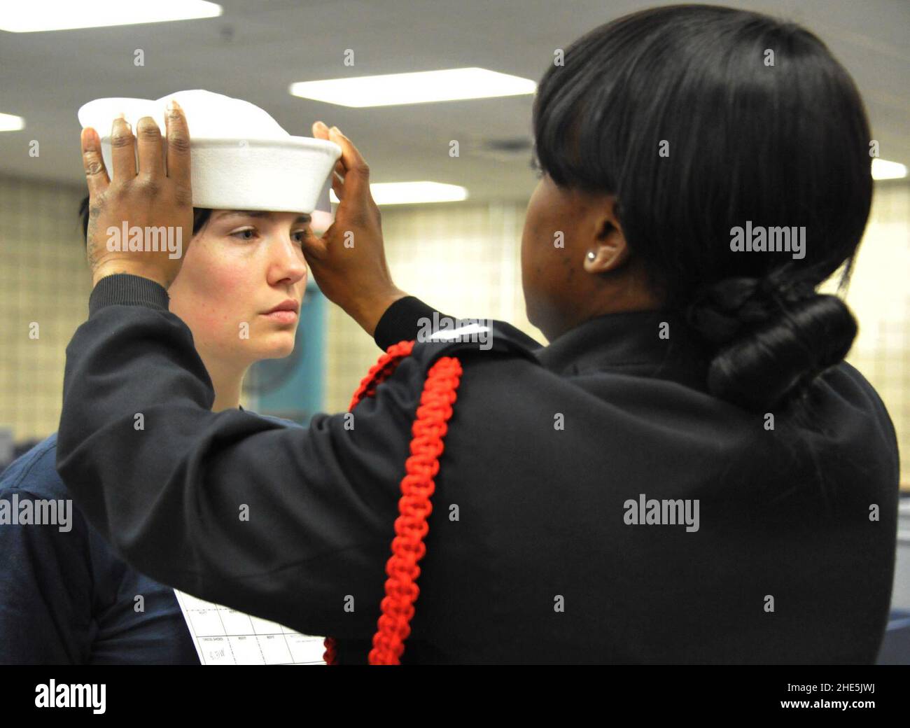 Sailor ensures the proper fit of Seaman's white enlisted hat, or ...