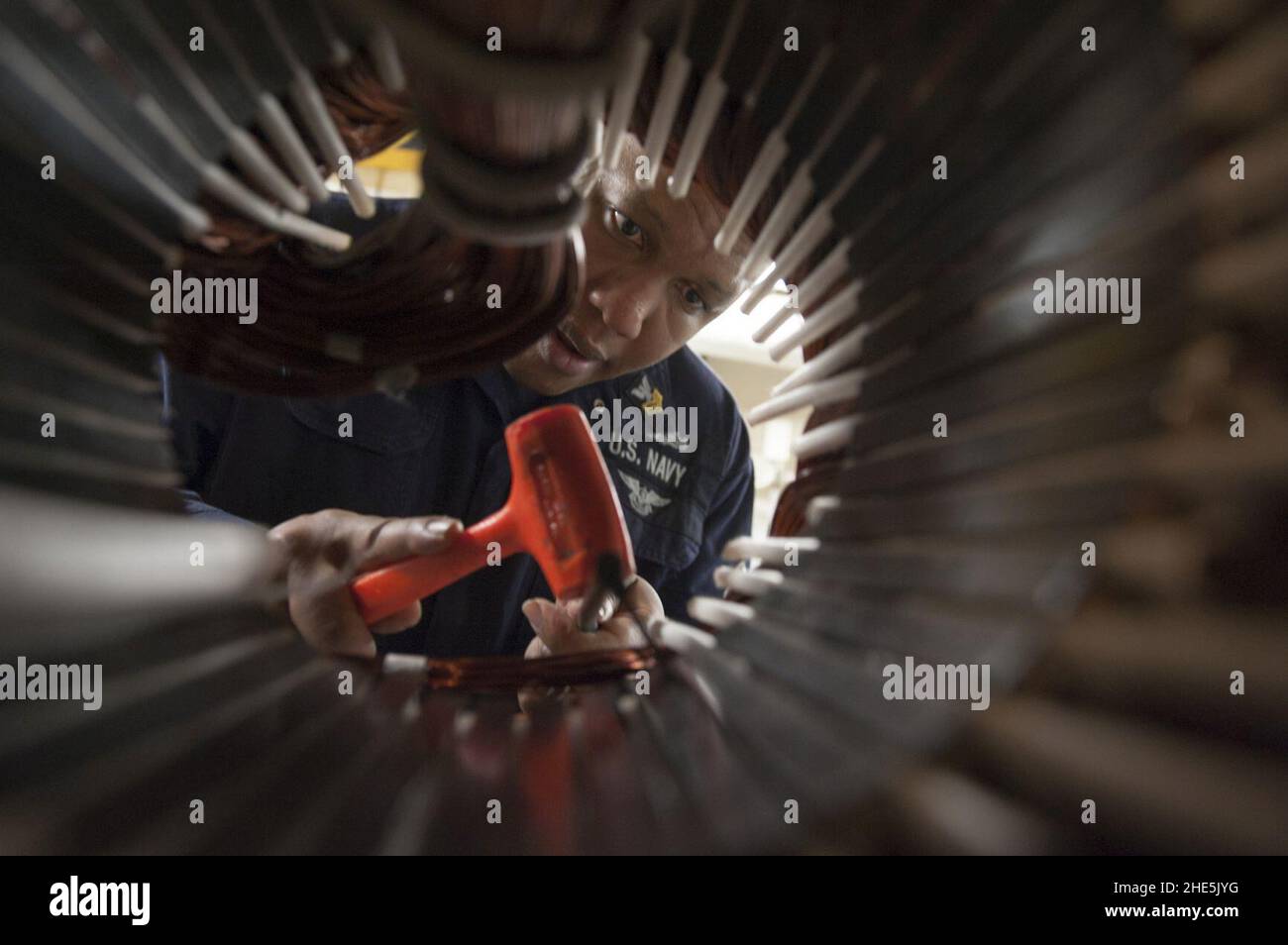 Sailor installs wiring inside a refrigerator compressor motor ...