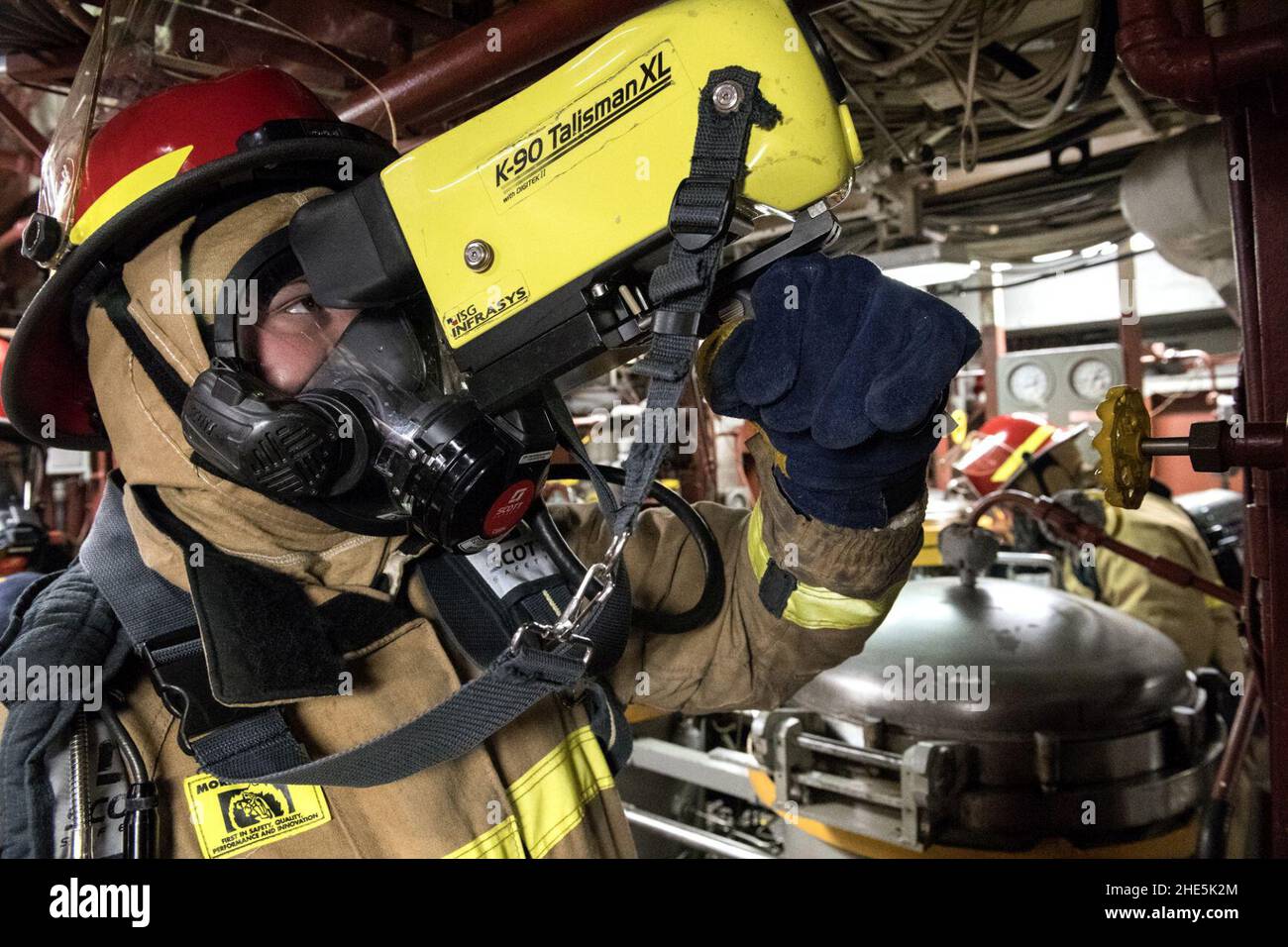 Sailor looks through a firefighting thermal imager during a fire drill ...