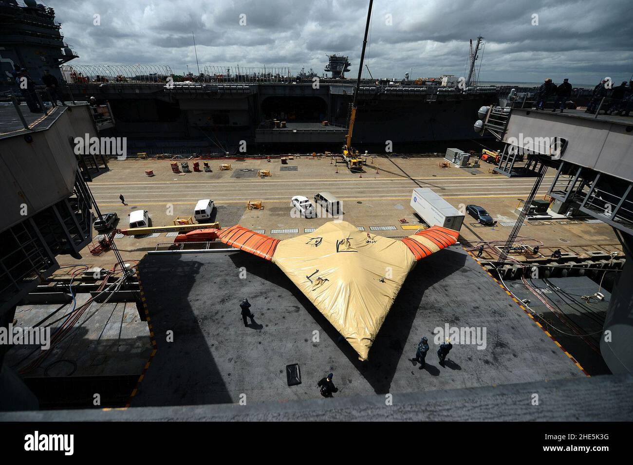 Sailor moves an X-47B is lowered in aircraft elevator aboard USS George ...