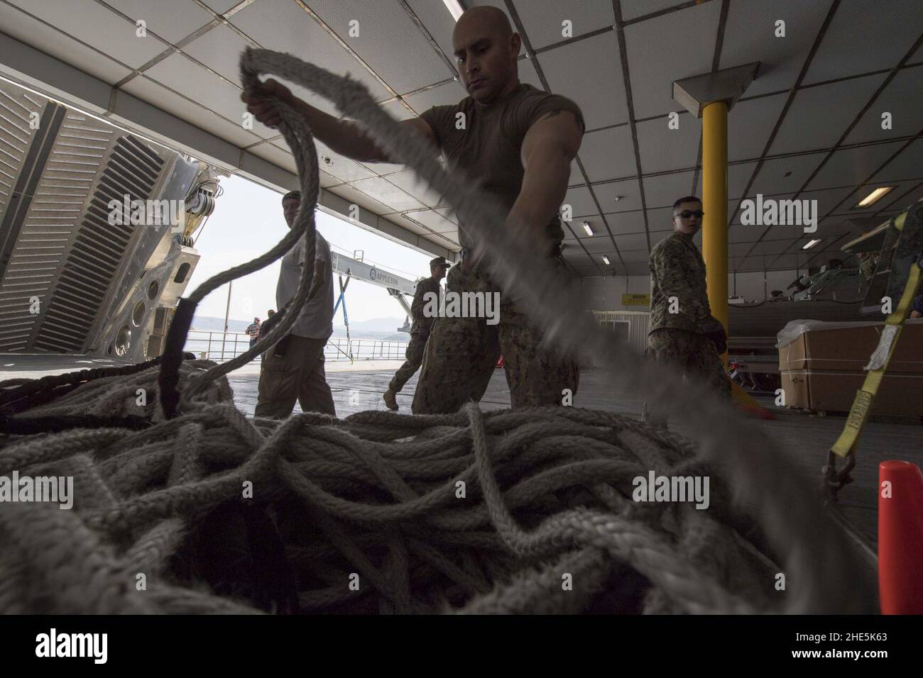 Sailor of USNS Carson City (T-EPF-7) stowing line during departure from ...