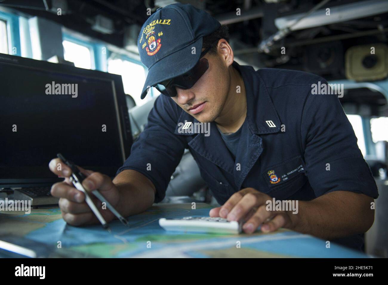 Sailor plots a track in the pilothouse of guided-missile destroyer USS ...