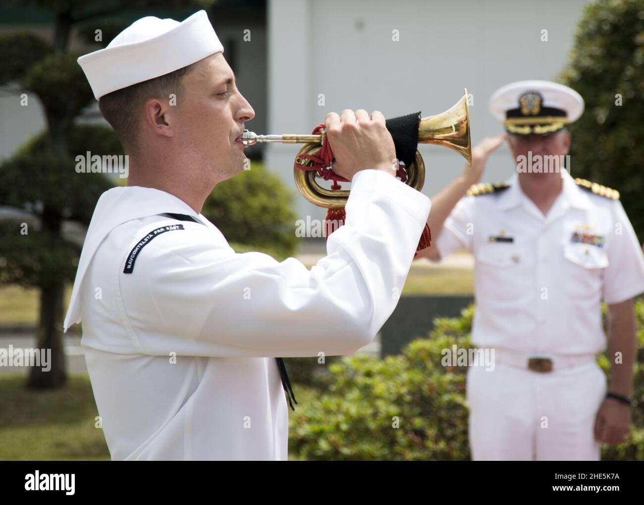 Sailor plays Taps on a bugle during the Battle of Midway commemoration ...