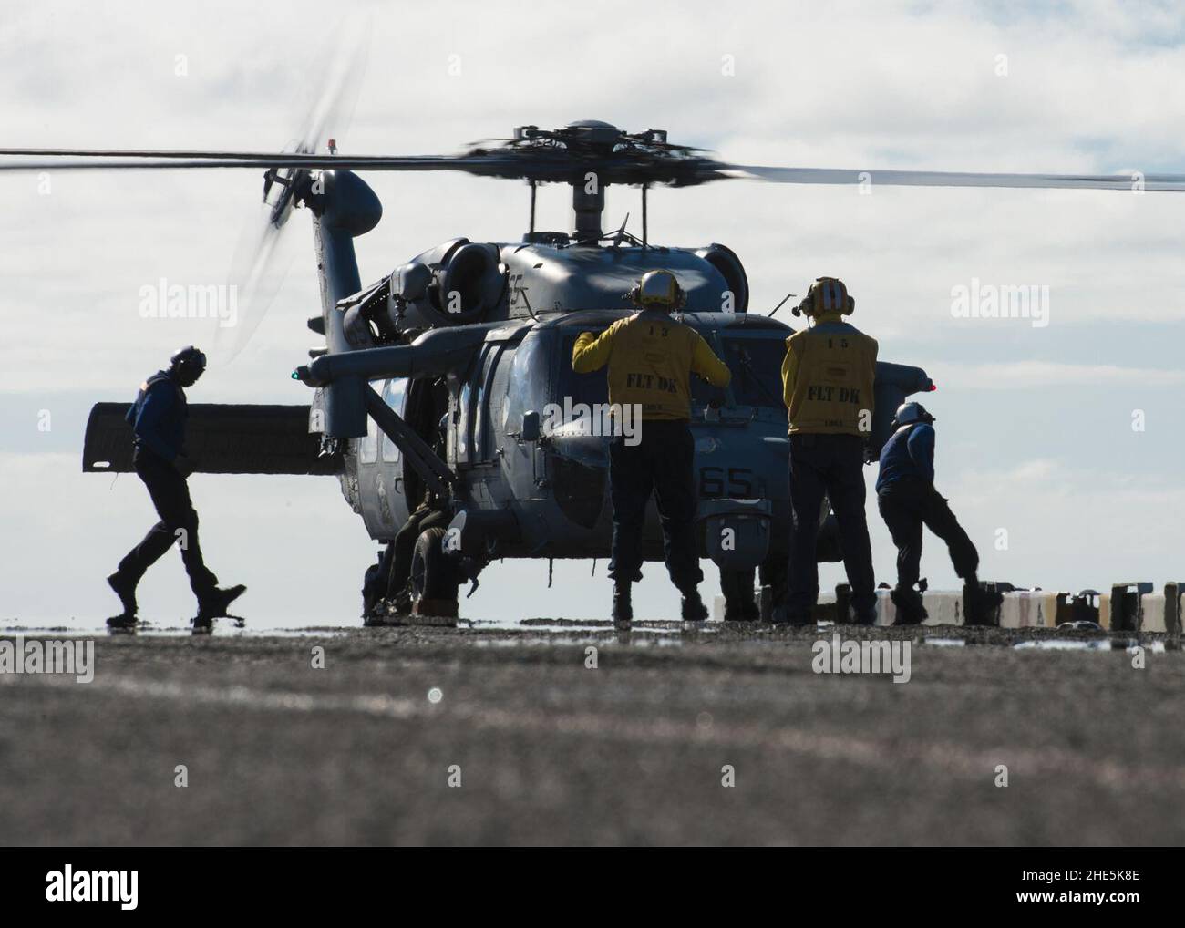 Sailor remove chocks and chains from an MH-60S Sea Hawk aboard USS ...