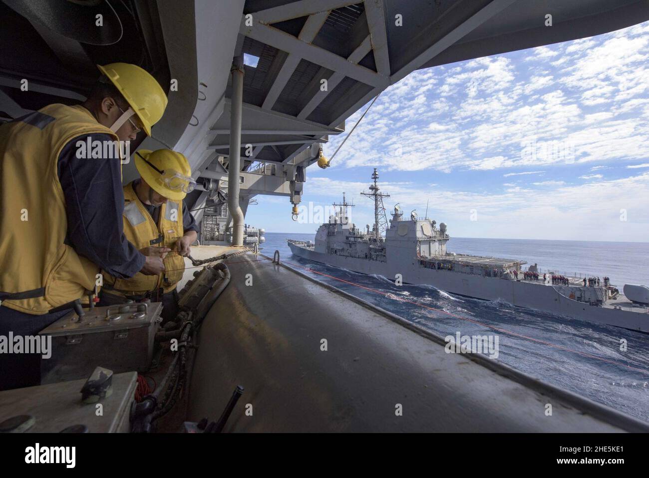Sailor ties a messenger line to a shot line on a fueling sponson of USS ...