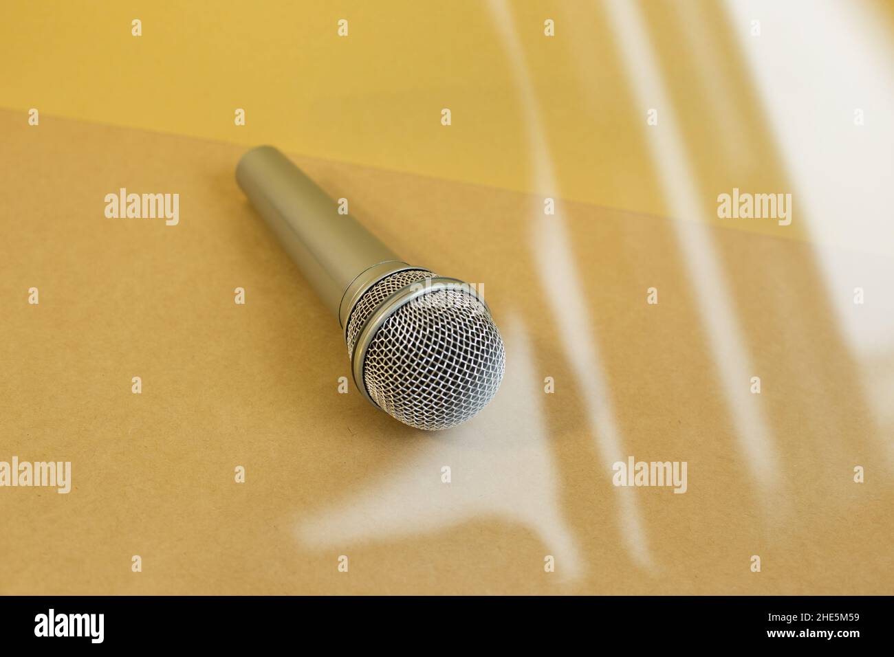 Microphone on brown floor background. from glass window Stock Photo - Alamy