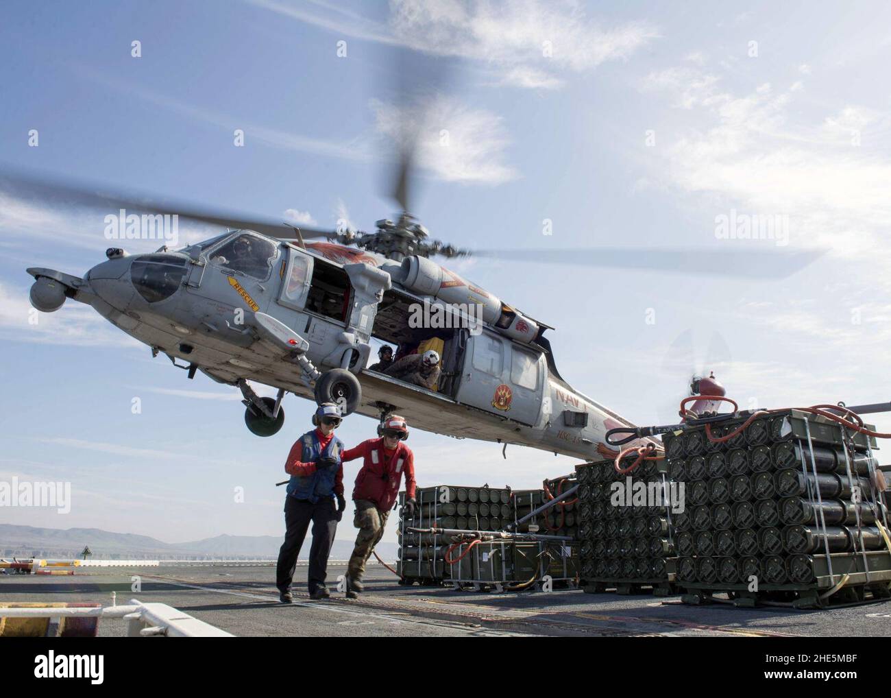Sailors clear an MH-60S Sea Hawk as it takes off from the flight deck ...