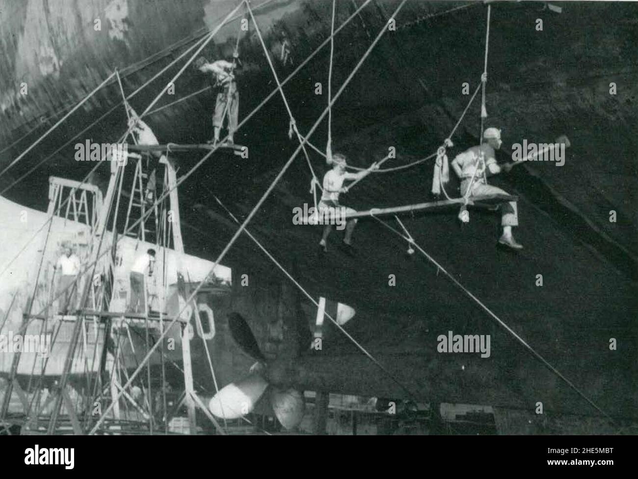 Sailors clean the bottom of USS Lunga Point (CVE-94) in a floating ...