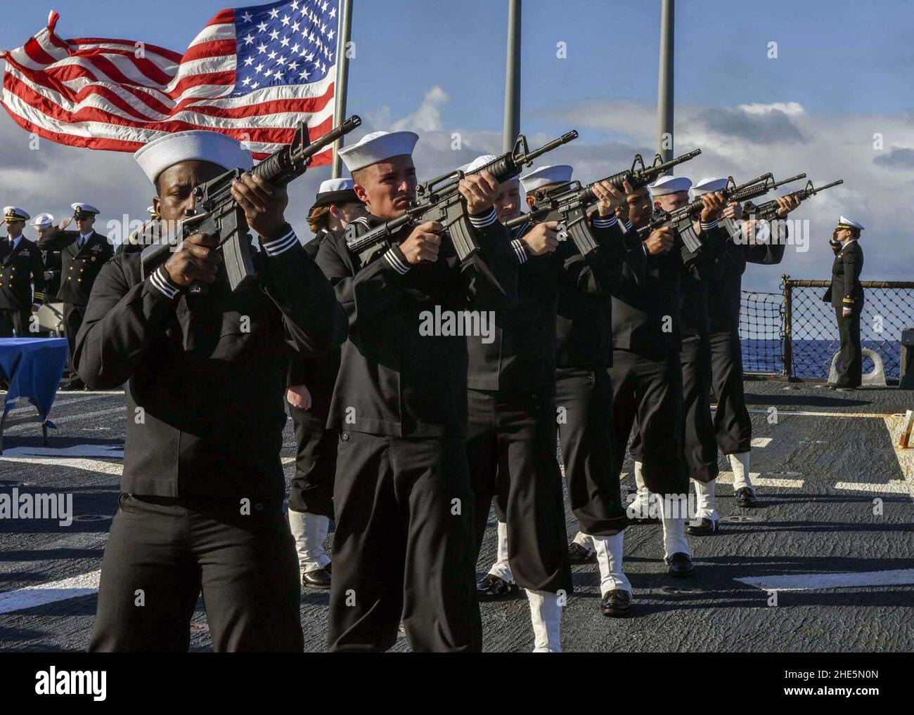 Sailors fire the first of three volleys to honor the deceased during a ...