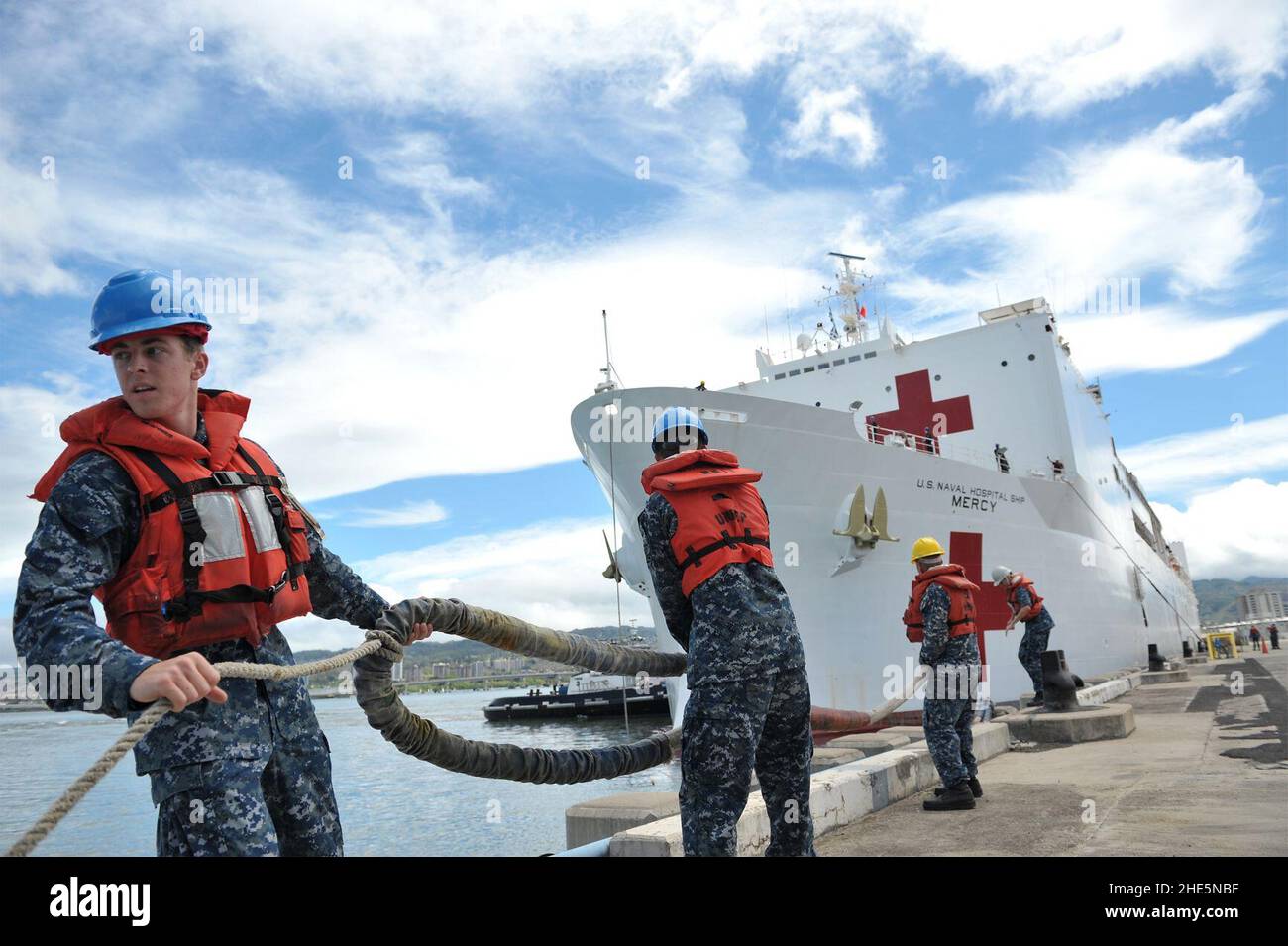 Sailors handle line as the hospital ship USNS Mercy moors at JBPHH ...