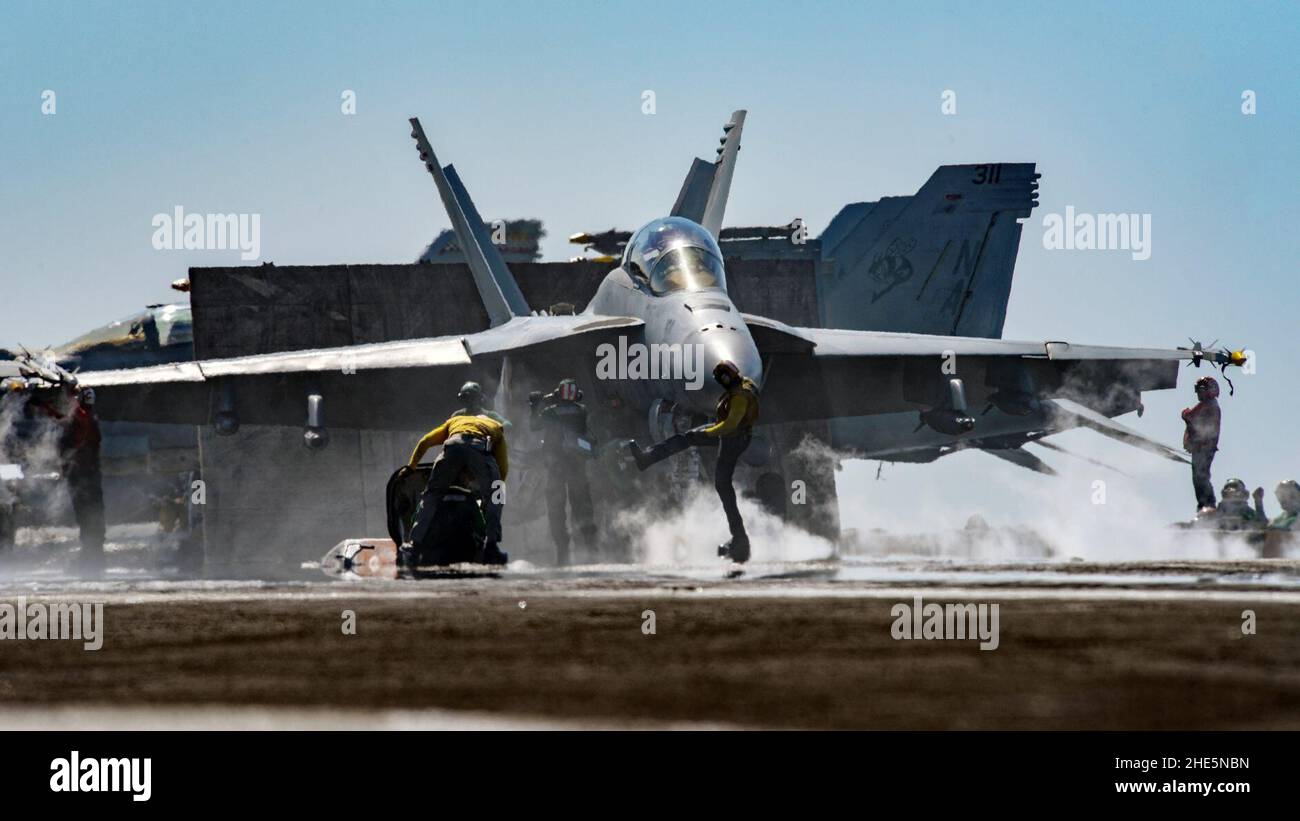 Sailors guide an F A-18F Super Hornet onto a catapult on the flight ...