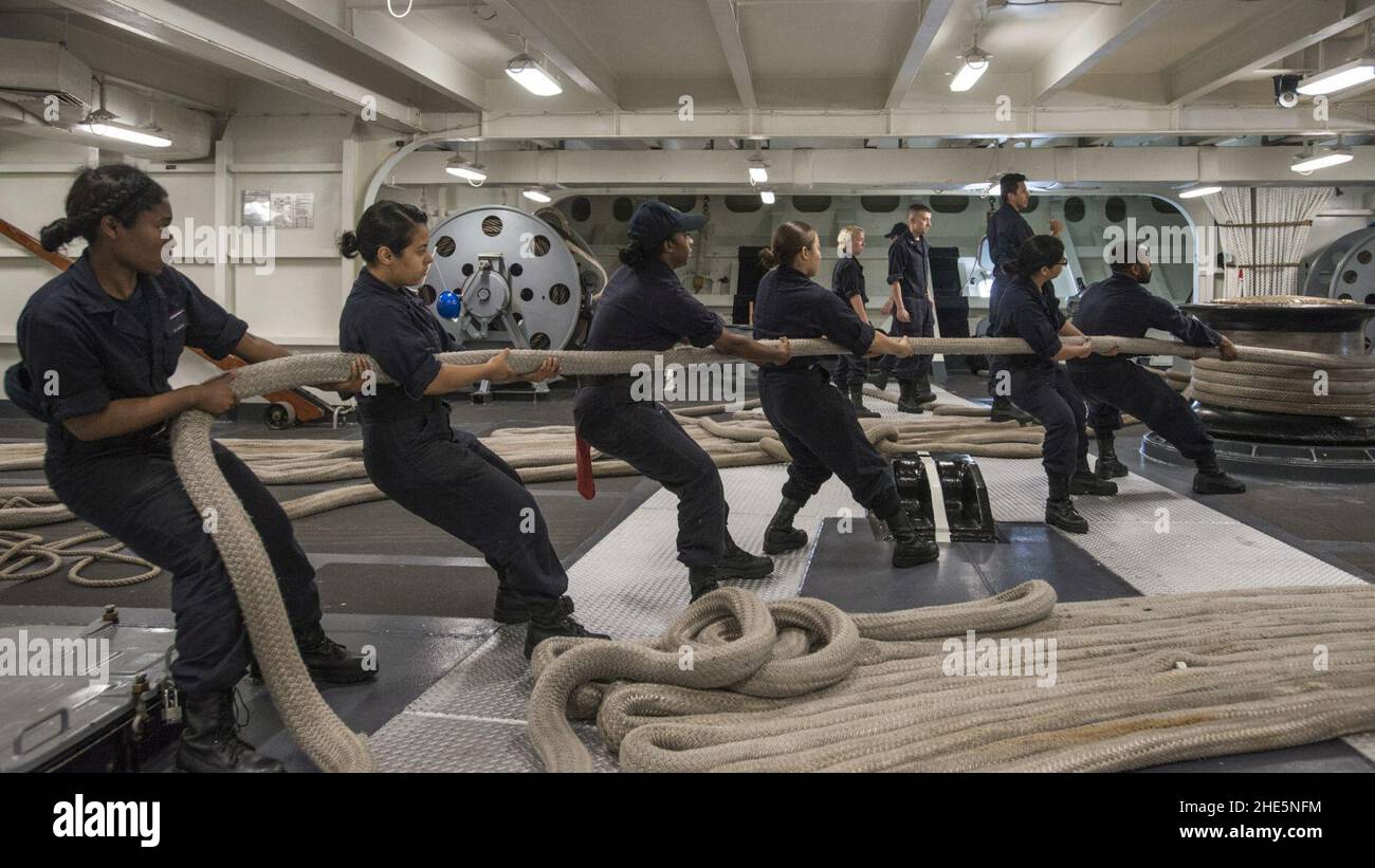 Sailors haul in mooring lines during a sea-and-anchor evolution aboard USS Ronald Reagan ...