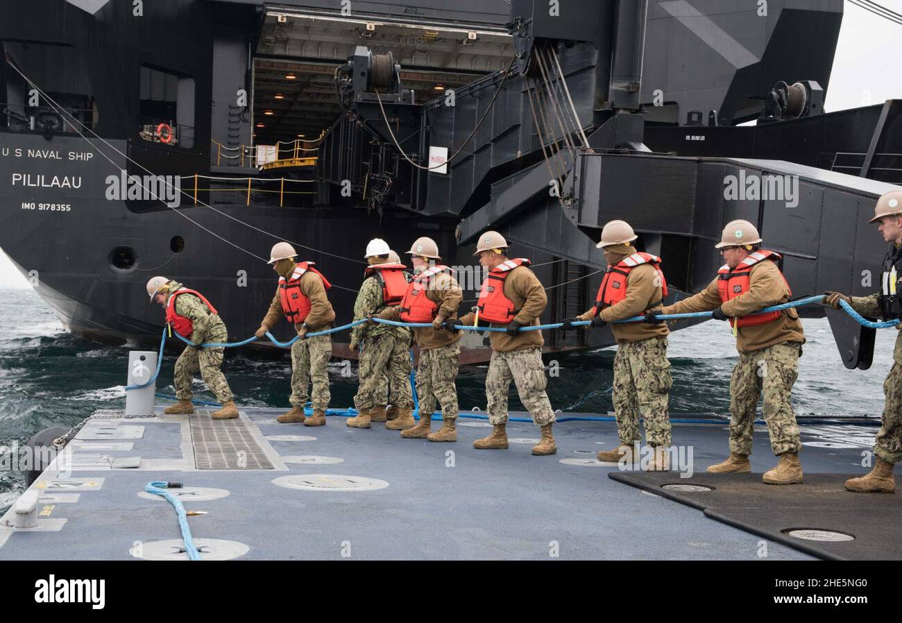 Sailors haul in a spring line to secure the Improved Navy Lighterage ...
